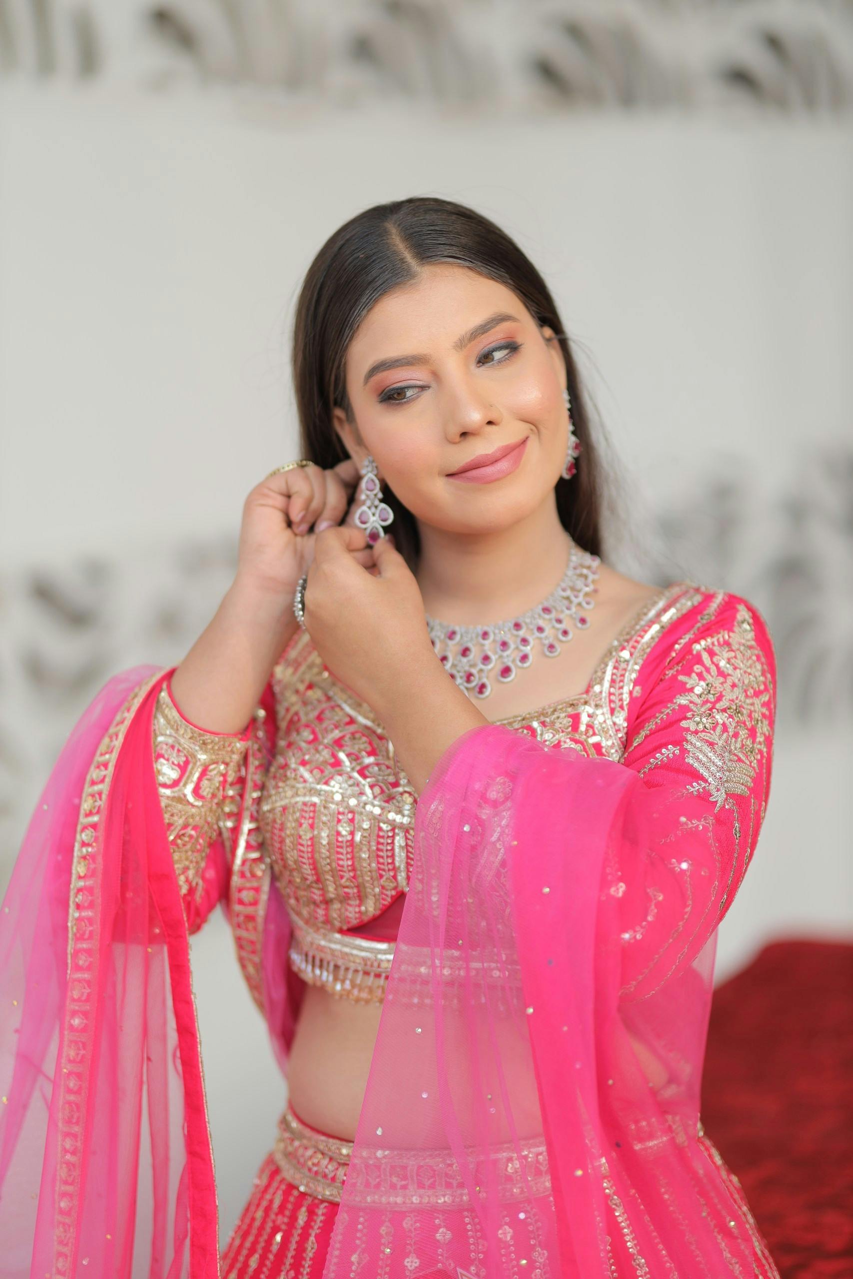 Indian Bride in Pink Lehenga Adjusting Earrings · Free Stock Photo