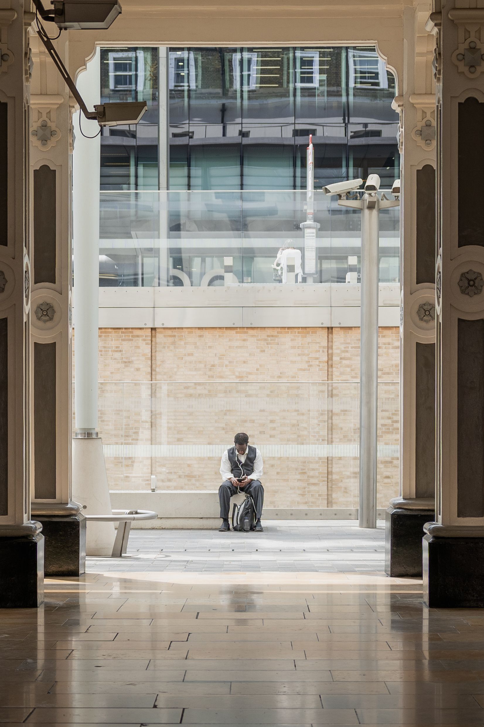 Man Sitting Alone at Modern Train Station · Free Stock Photo
