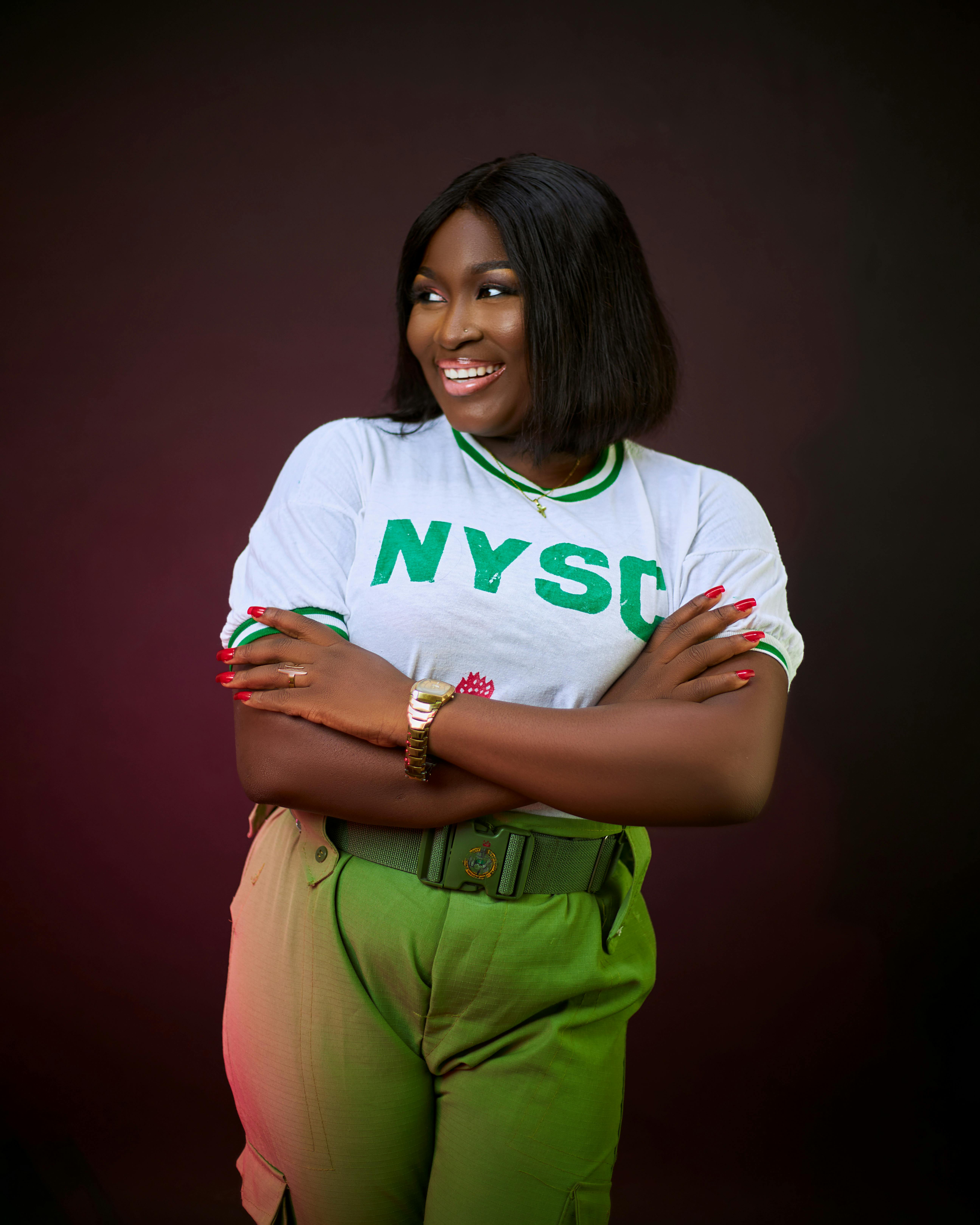 Smiling Woman in NYSC Uniform Against Dark Background · Free Stock Photo
