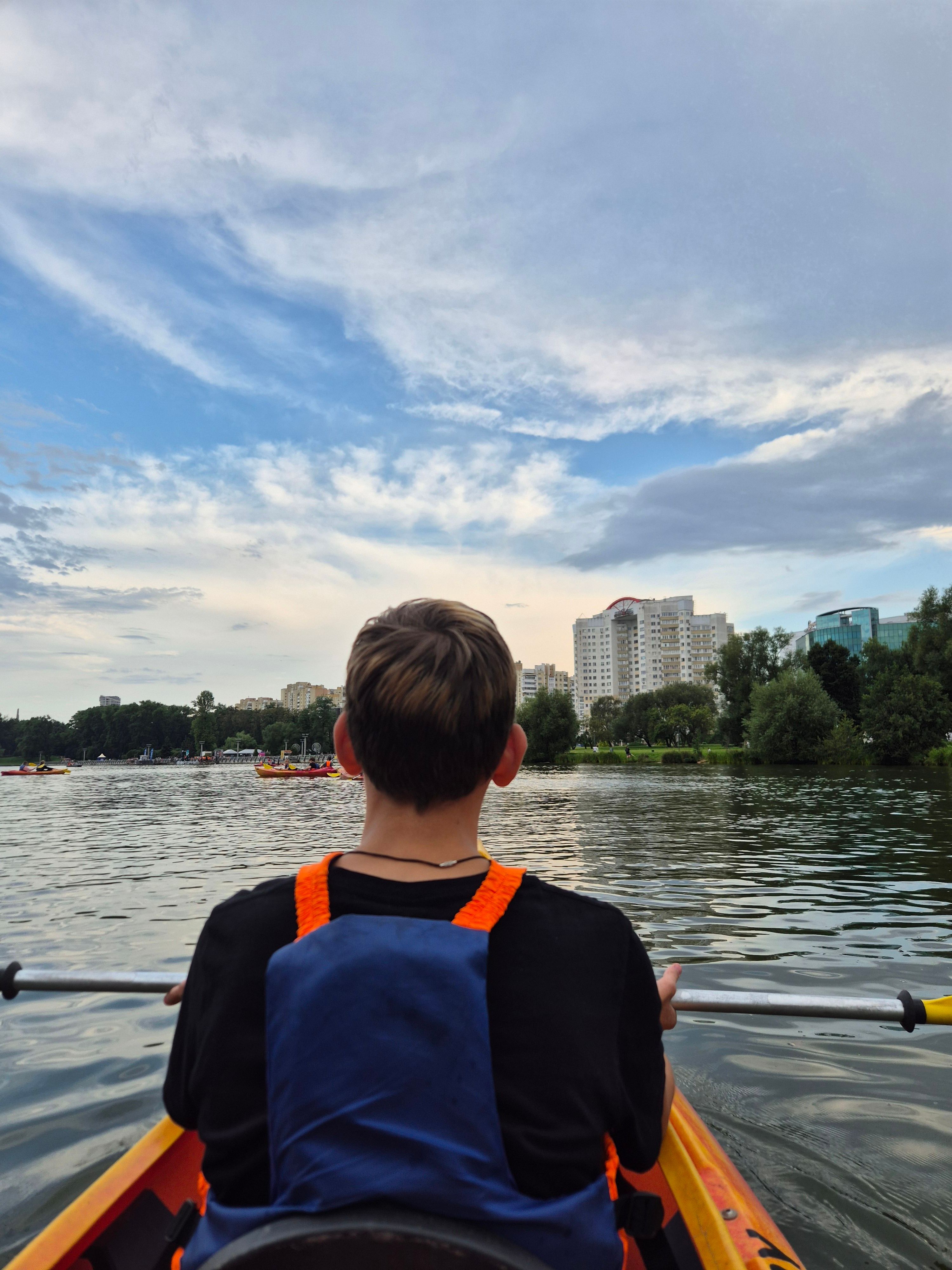 Person Kayaking on a Serene Urban Lake · Free Stock Photo