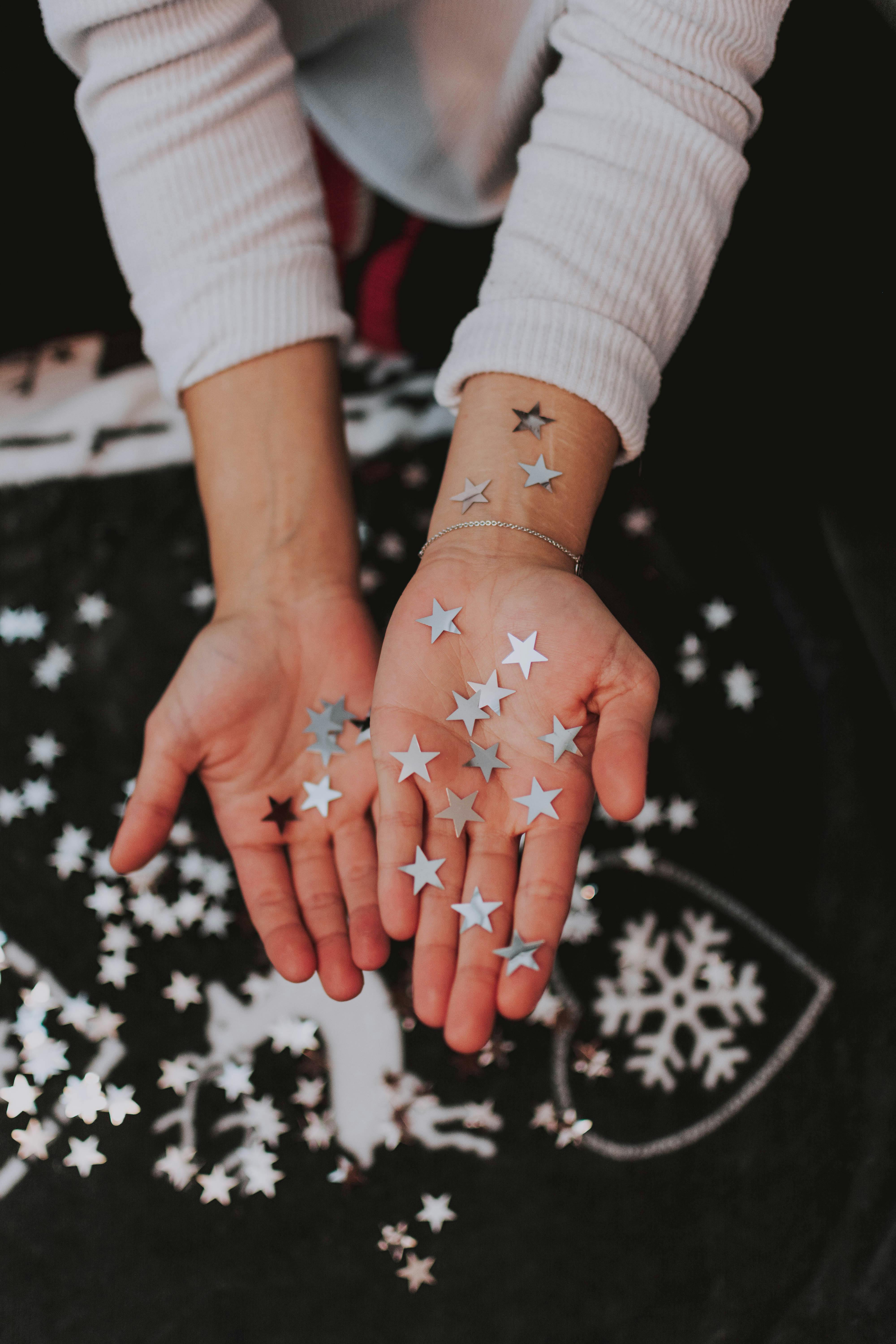 Crop woman with silver paper stars decorating Christmas toys · Free ...