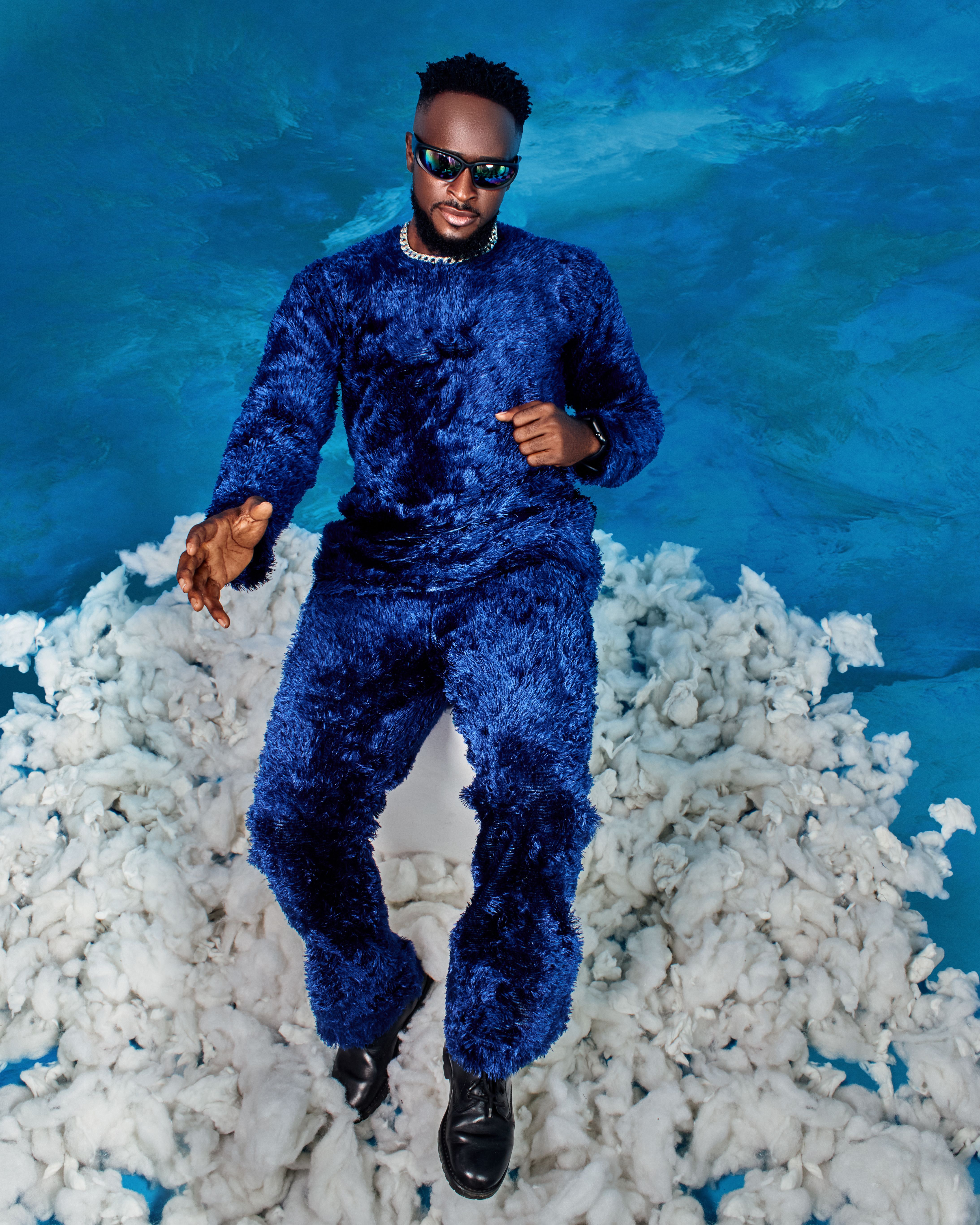 Man in Blue Furry Outfit on Cloudy Surface · Free Stock Photo