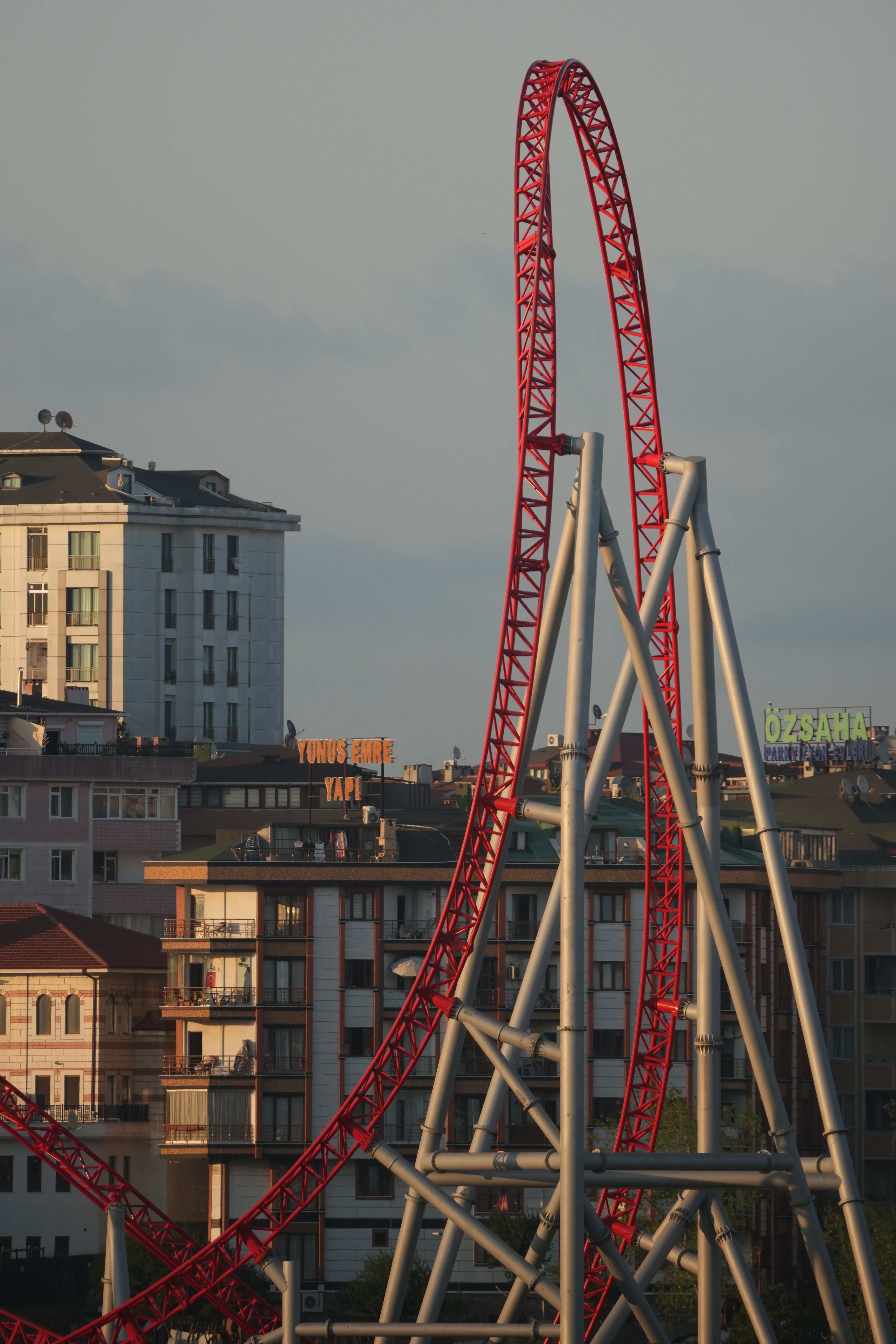 Red Roller Coaster Among Urban Buildings · Free Stock Photo