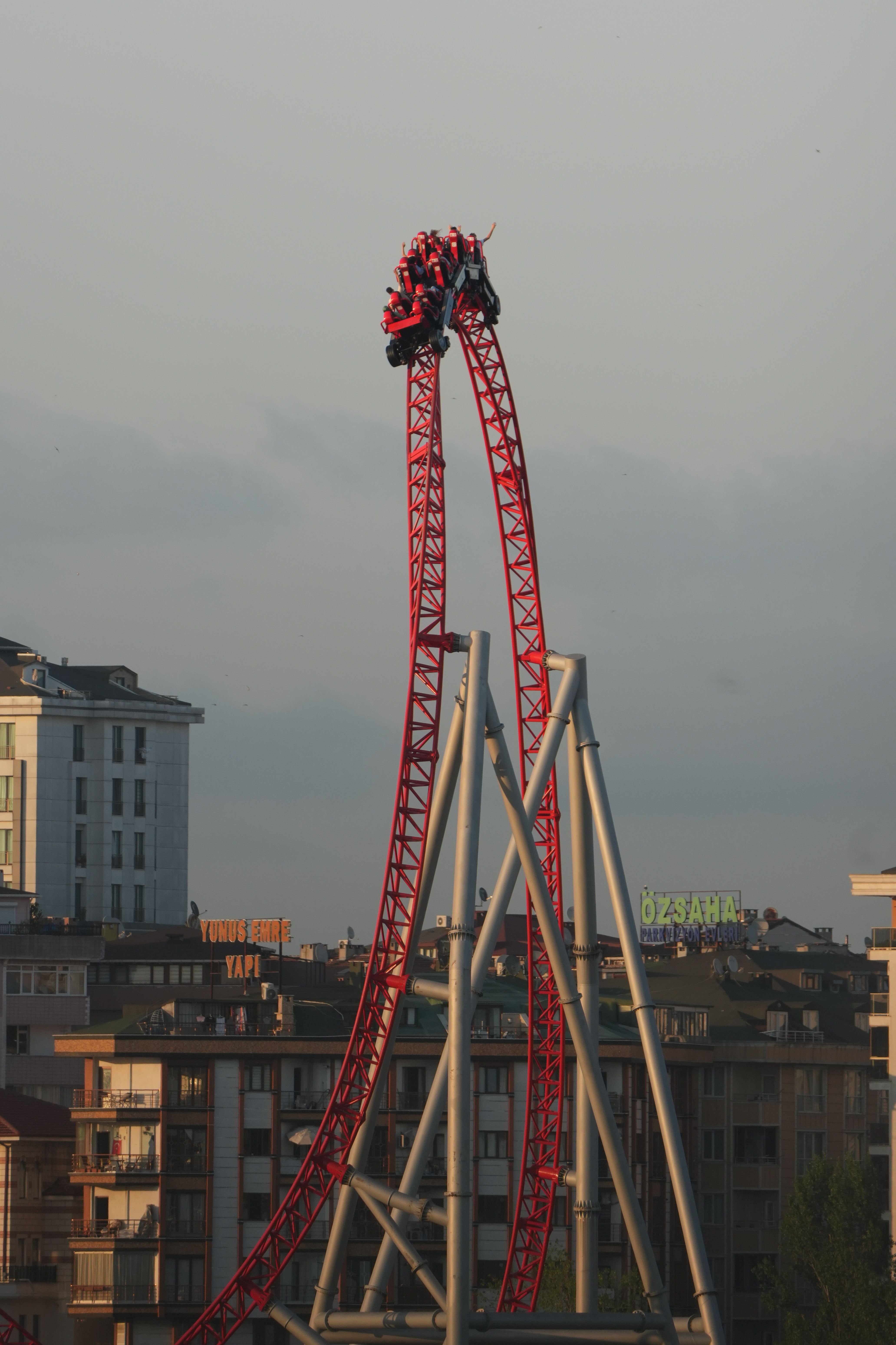 Red Roller Coaster Among Urban Buildings · Free Stock Photo