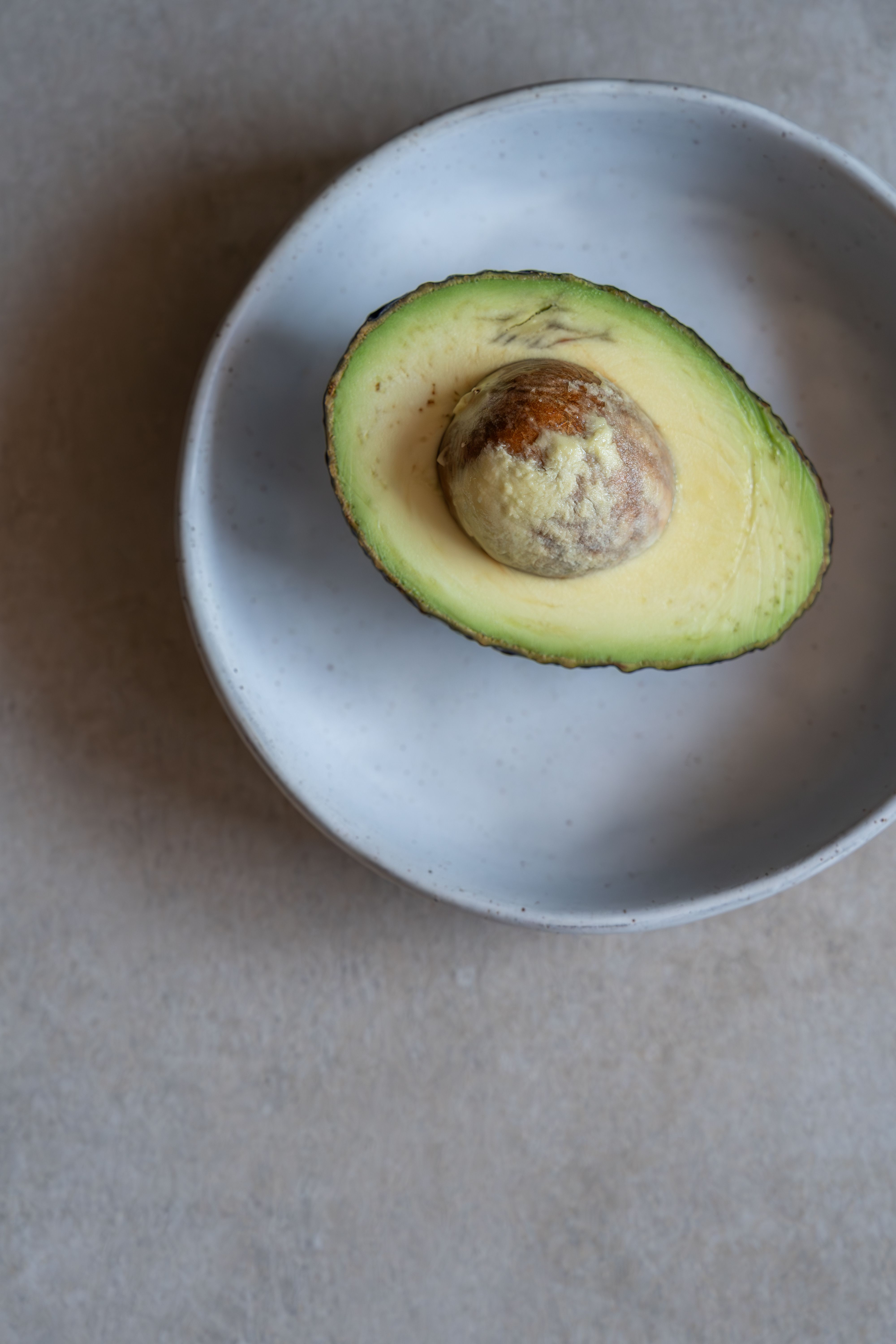 Close-Up of Avocado Half in Ceramic Bowl · Free Stock Photo