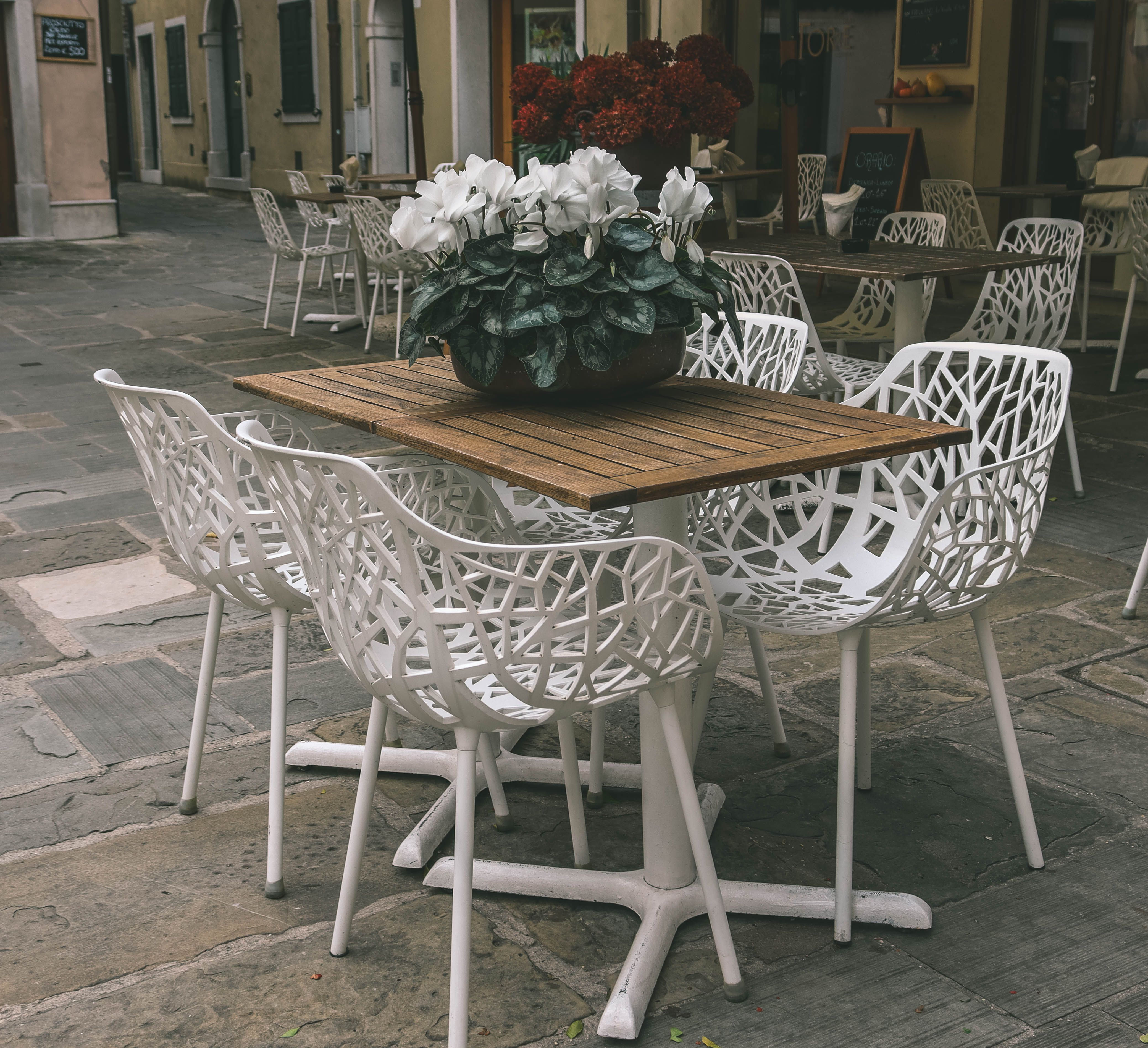 Charming Outdoor Cafe Seating with Floral Decor · Free Stock Photo