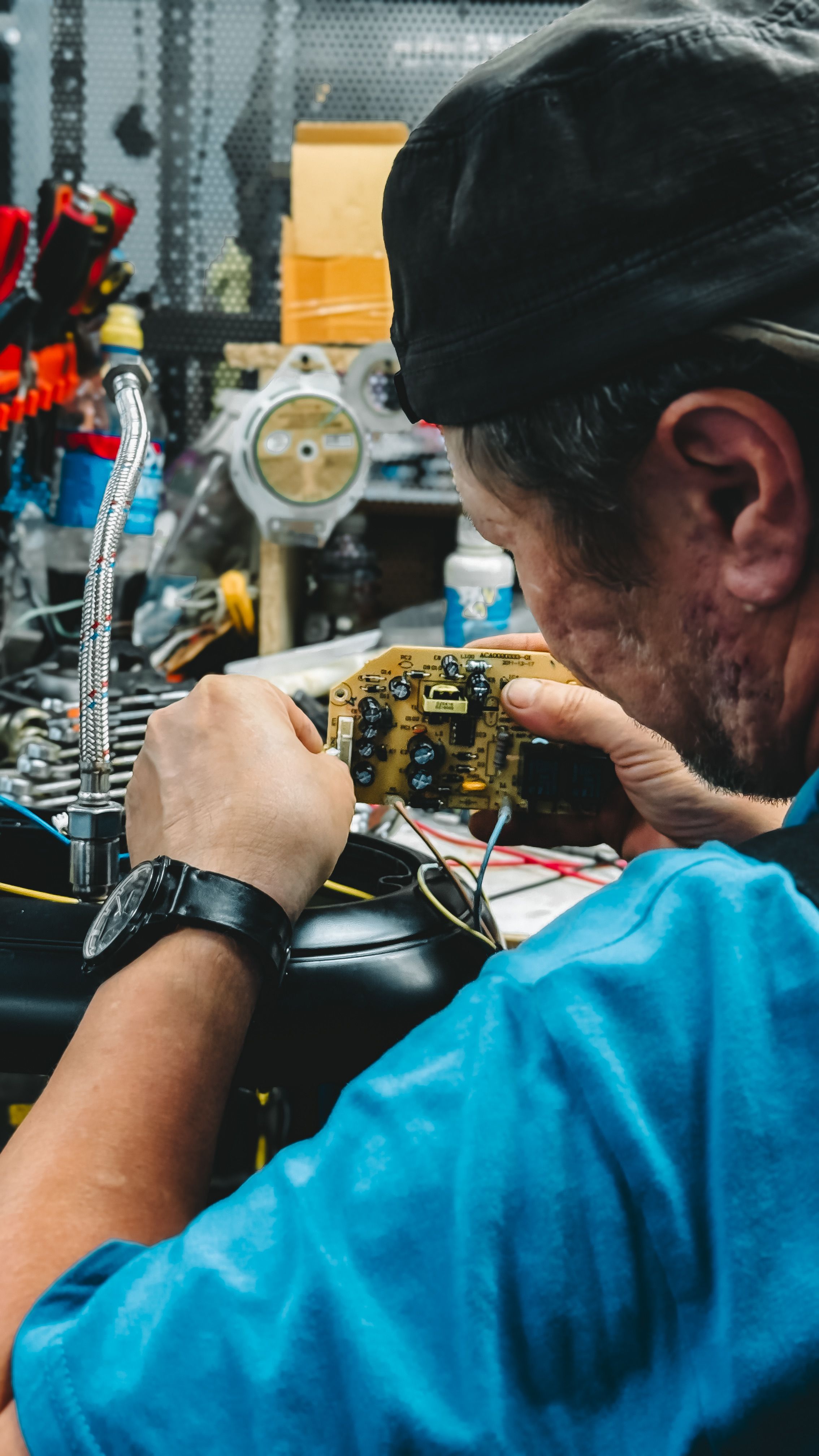 Man Repairing Electronics in Workshop · Free Stock Photo