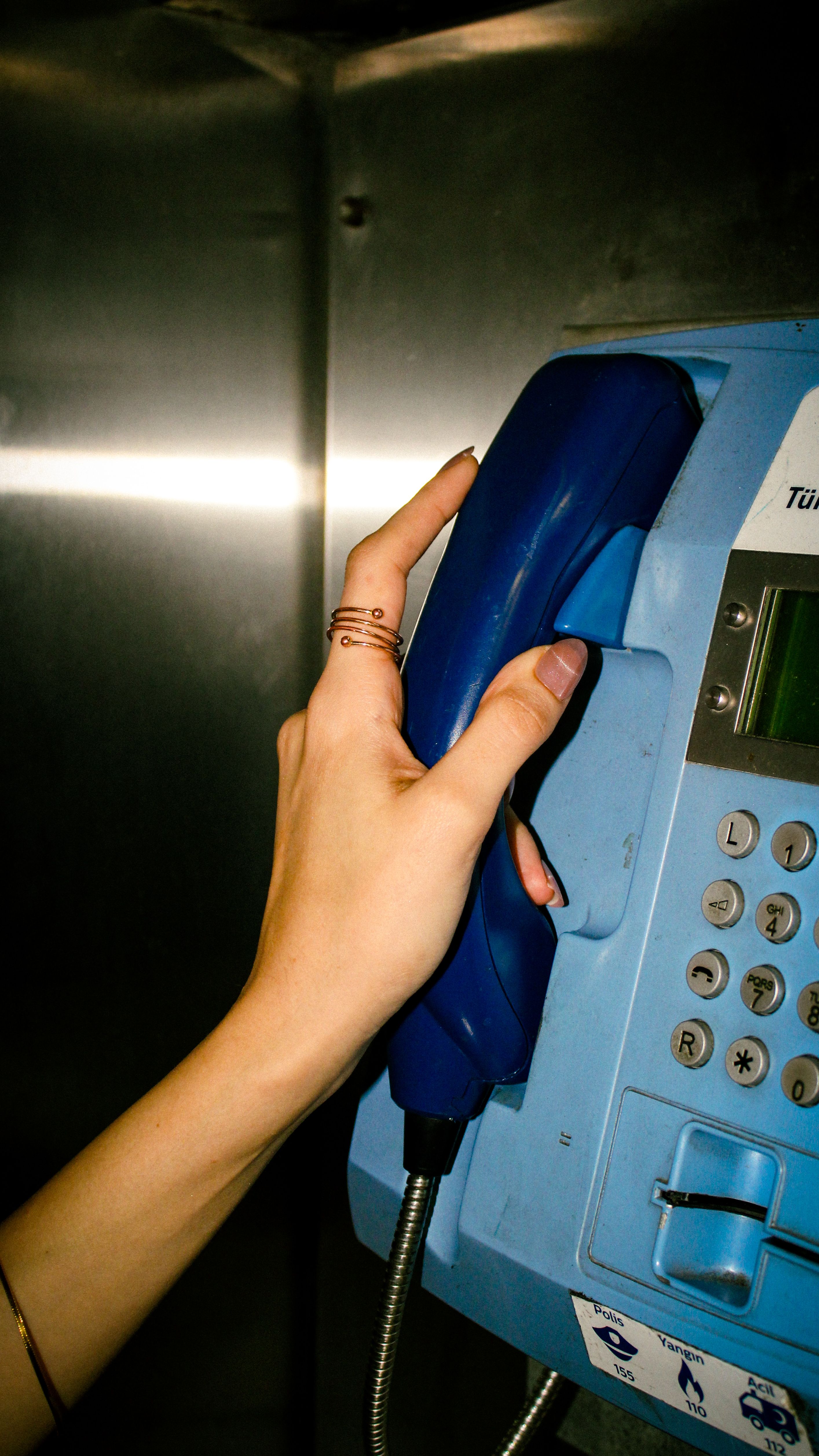 Close-up of Hand Using Blue Payphone Receiver · Free Stock Photo