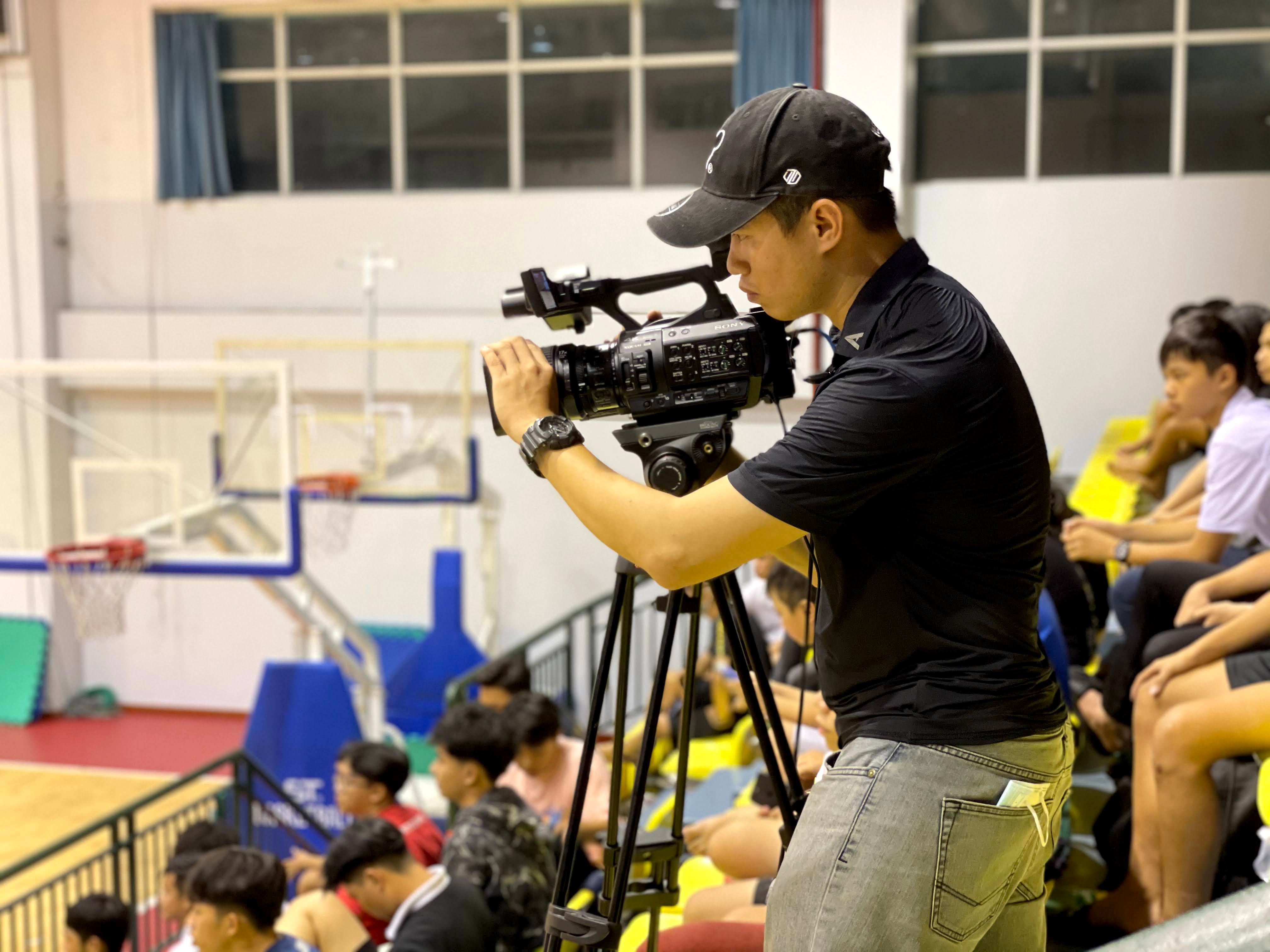 Cameraman Filming Indoor Sports Event · Free Stock Photo