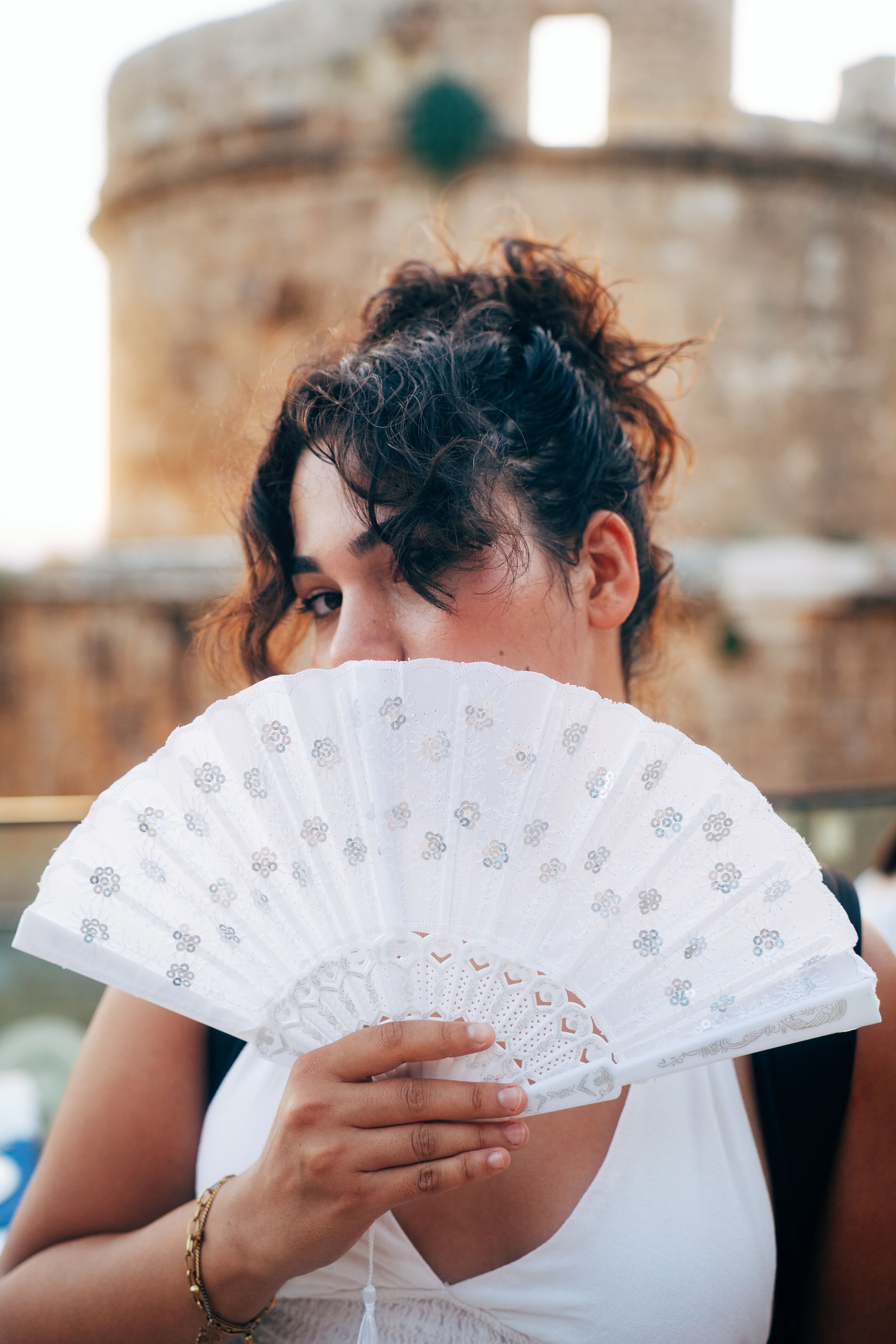 Woman with White Fan in Historic Cityscape · Free Stock Photo