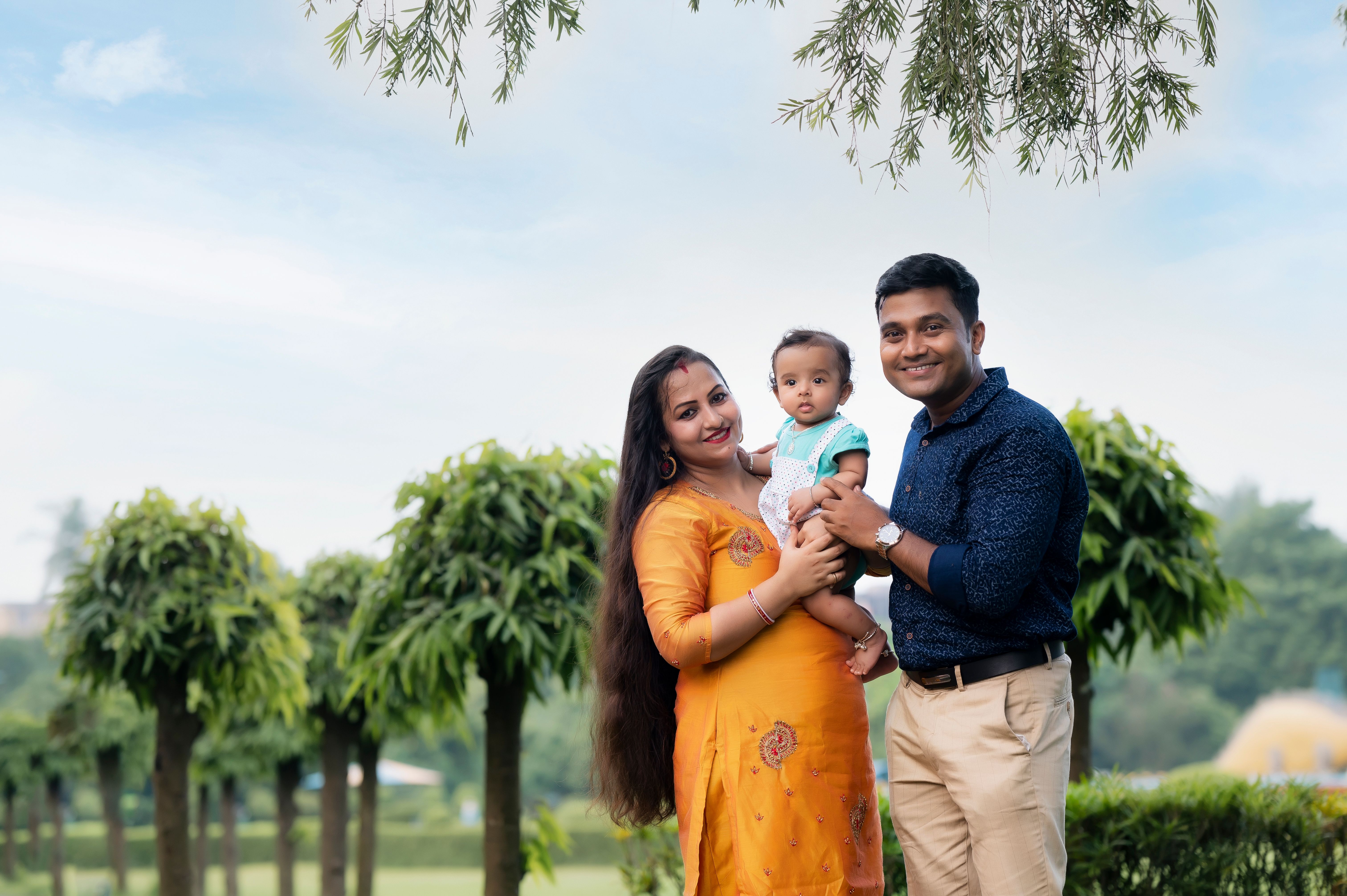 Happy Family Posing in Scenic Park Setting · Free Stock Photo