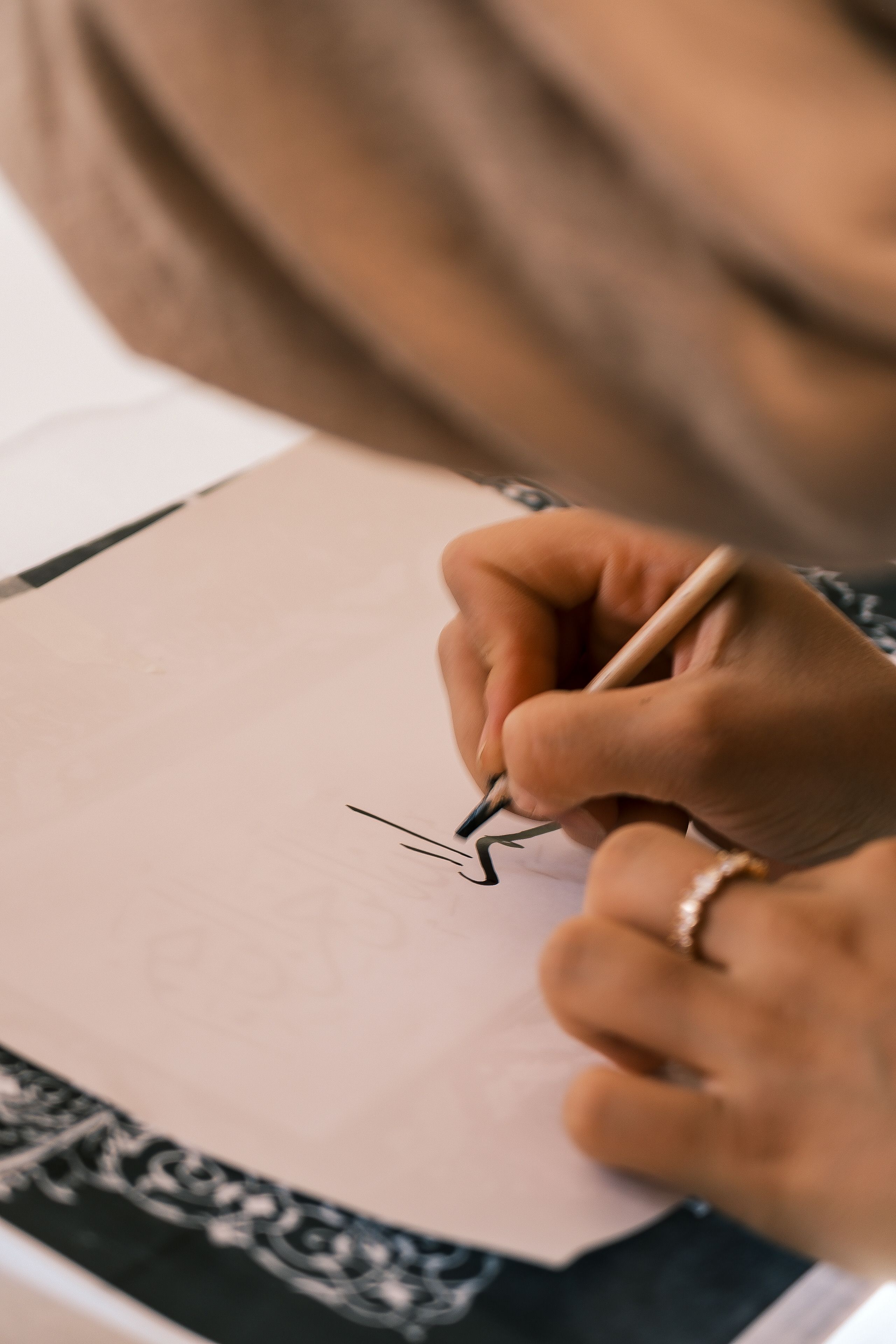 Person Writing on Brown Paper · Free Stock Photo