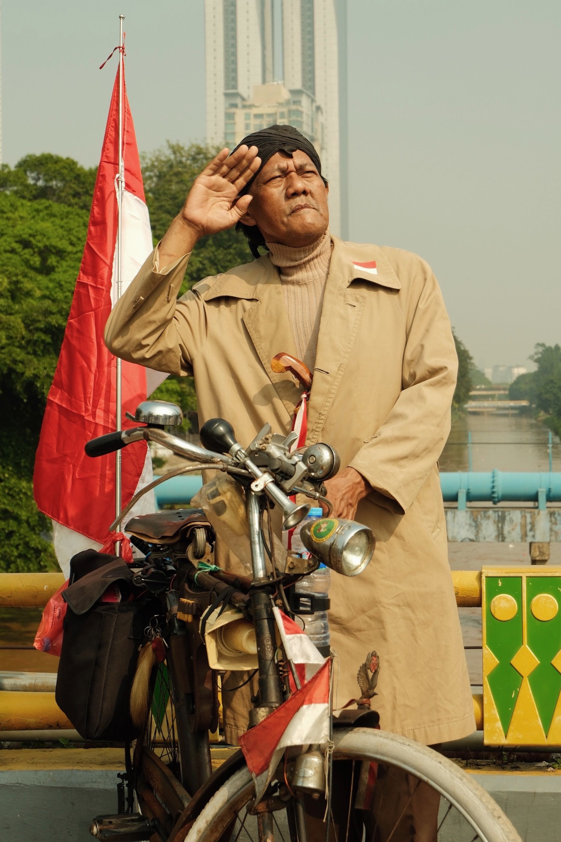 Elderly Man Saluting Next to Bicycle Outdoors · Free Stock Photo