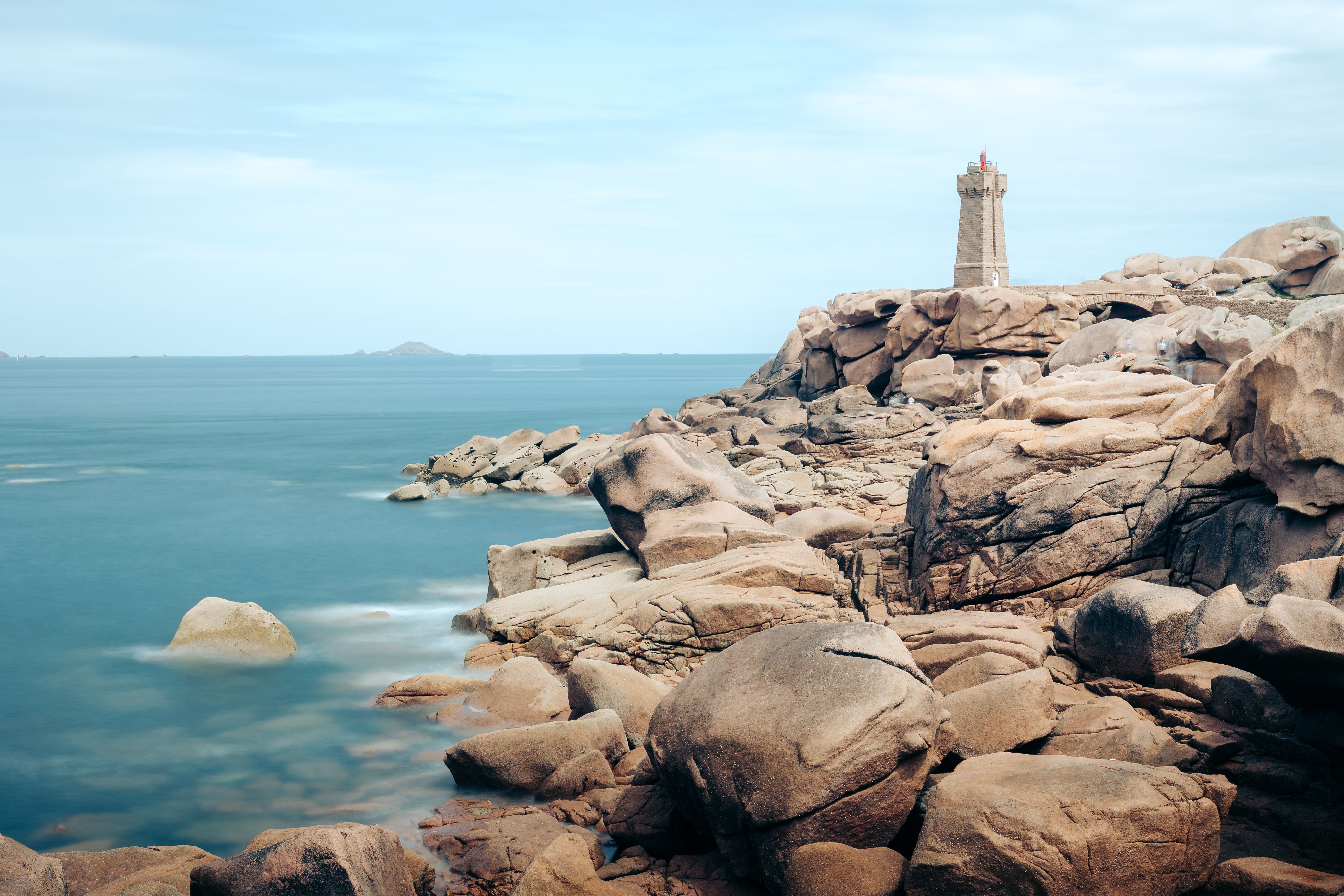 Picturesque Coastal Lighthouse Amidst Rugged Rocks · Free Stock Photo