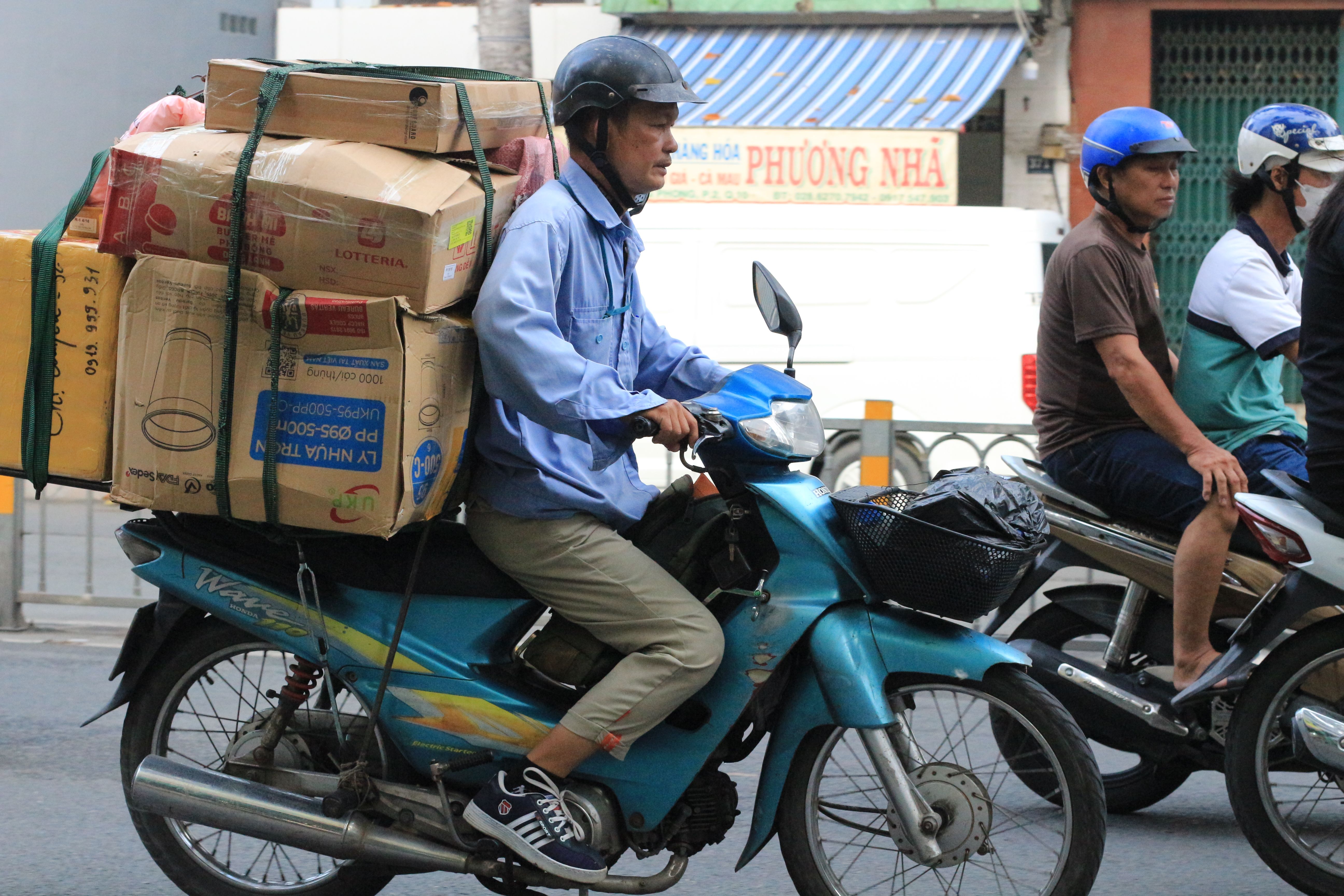Man Riding Motorbike Loaded with Boxes in Saigon · Free Stock Photo