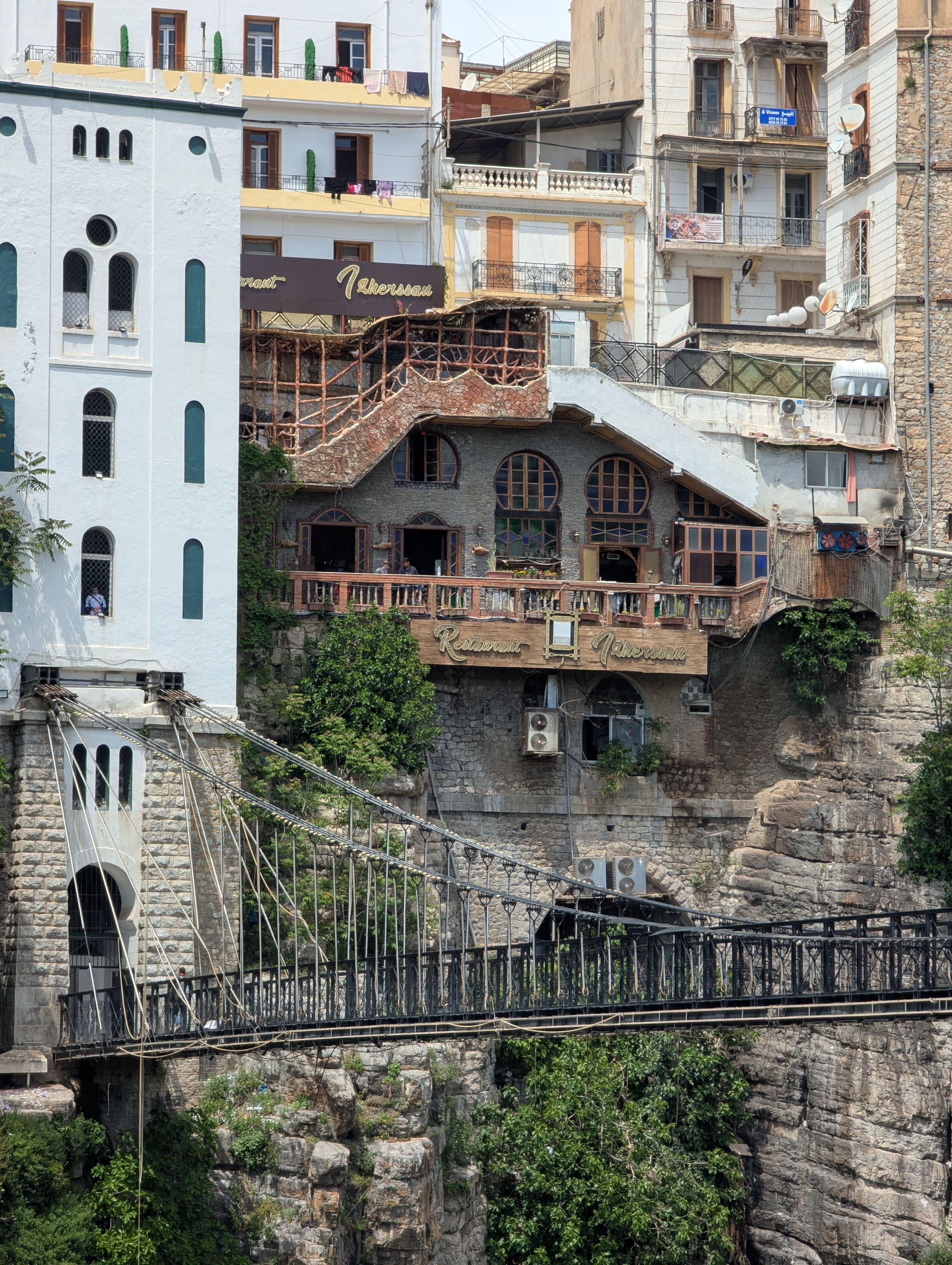 Suspension Bridge with Historic Cliff Buildings · Free Stock Photo