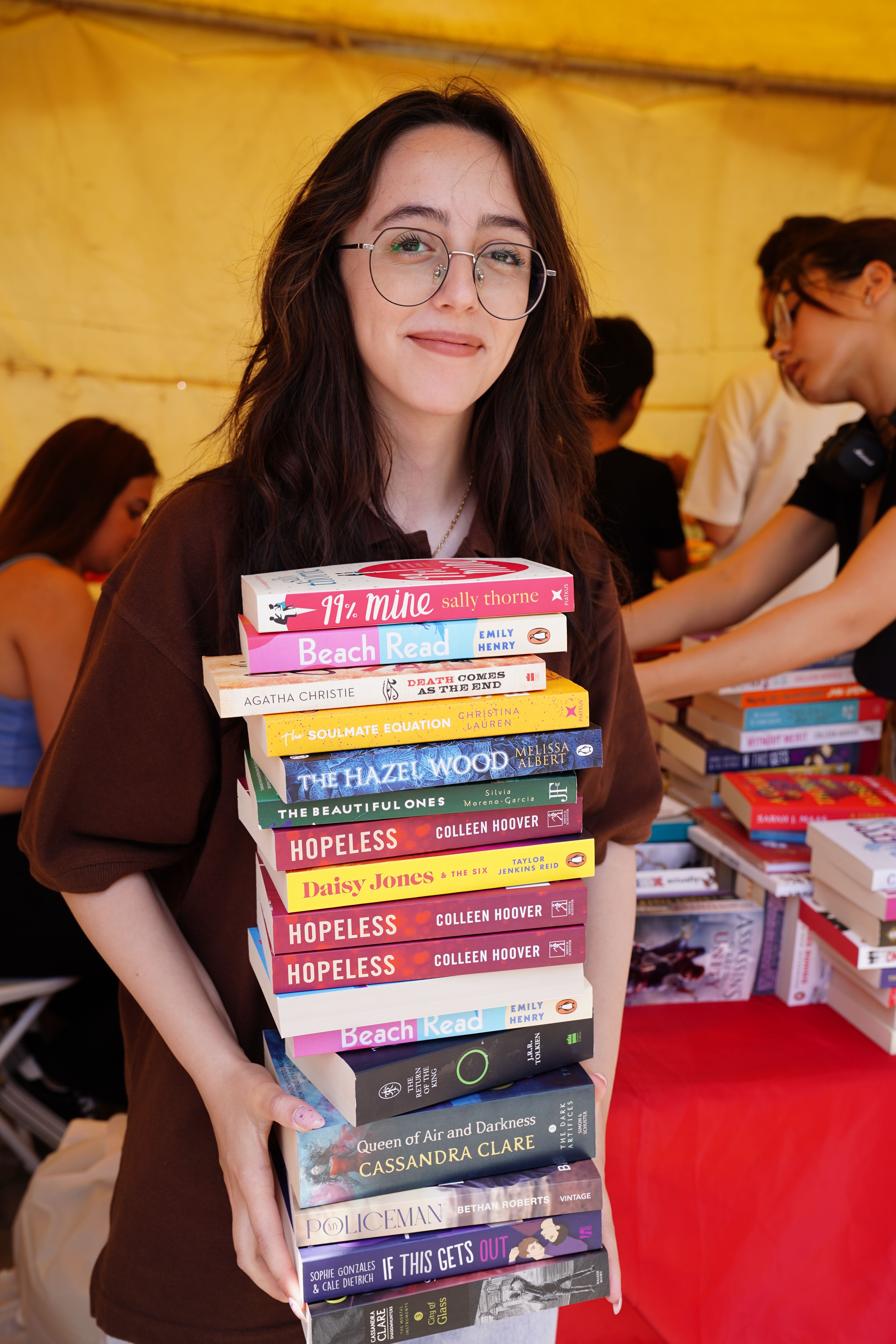 Young Woman Holding Stack of Popular Books · Free Stock Photo