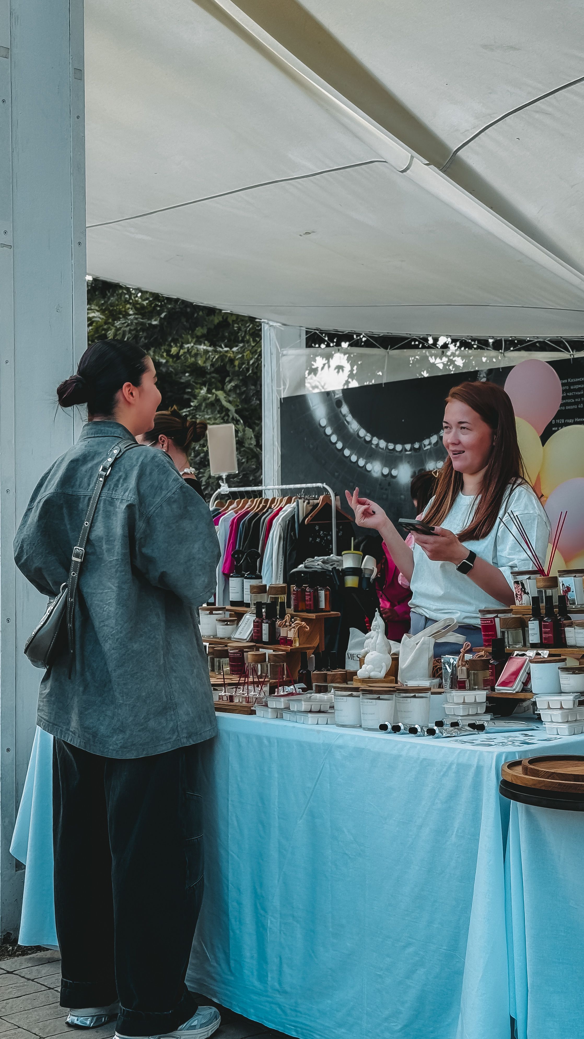 Lively Outdoor Market Scene with Vendor and Customer · Free Stock Photo