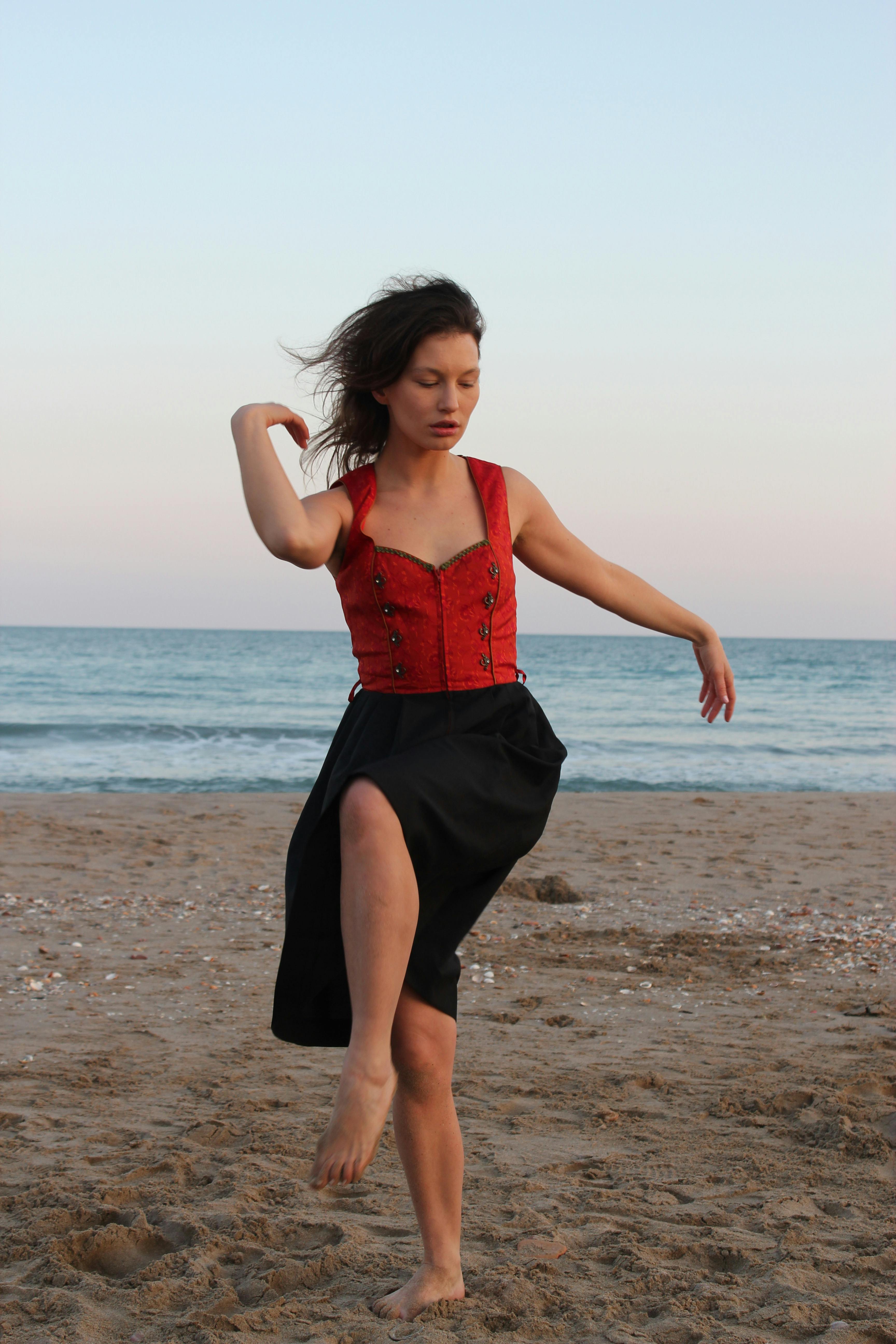 Woman Dancing Gracefully on Sandy Beach at Dusk · Free Stock Photo