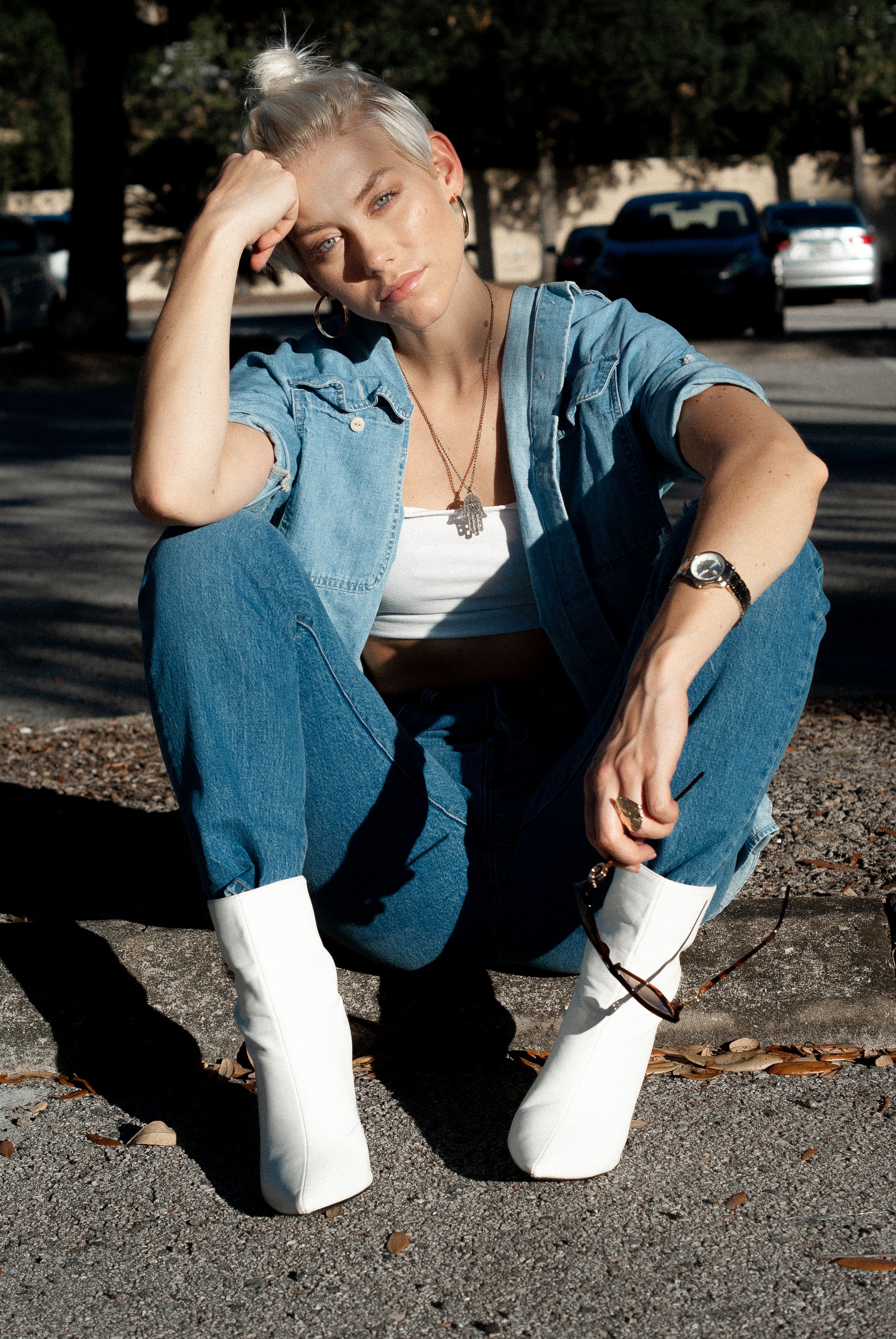Fashionable female sitting on street pavement · Free Stock Photo