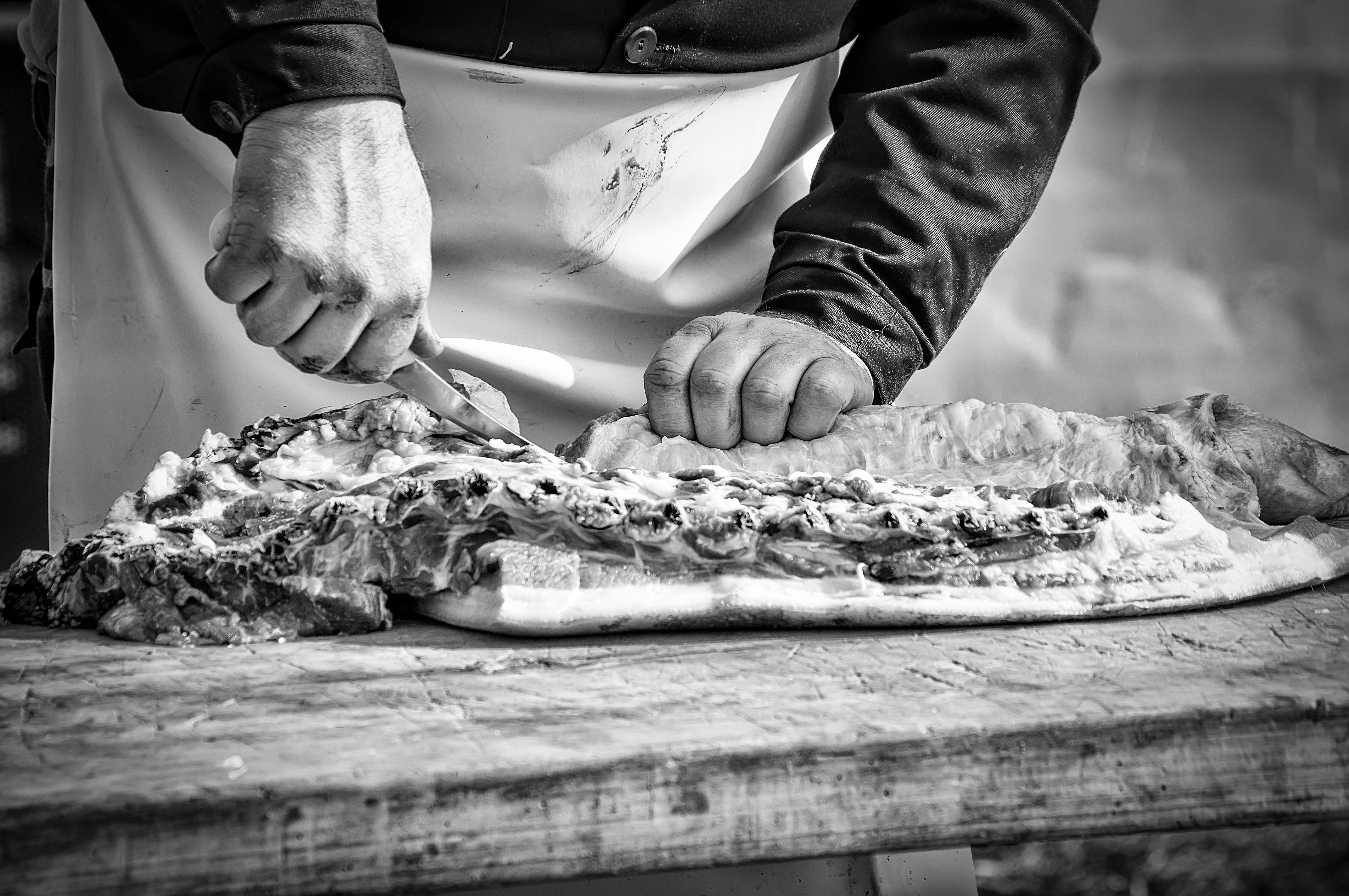 Butcher Skillfully Slicing Fresh Meat Outdoors · Free Stock Photo