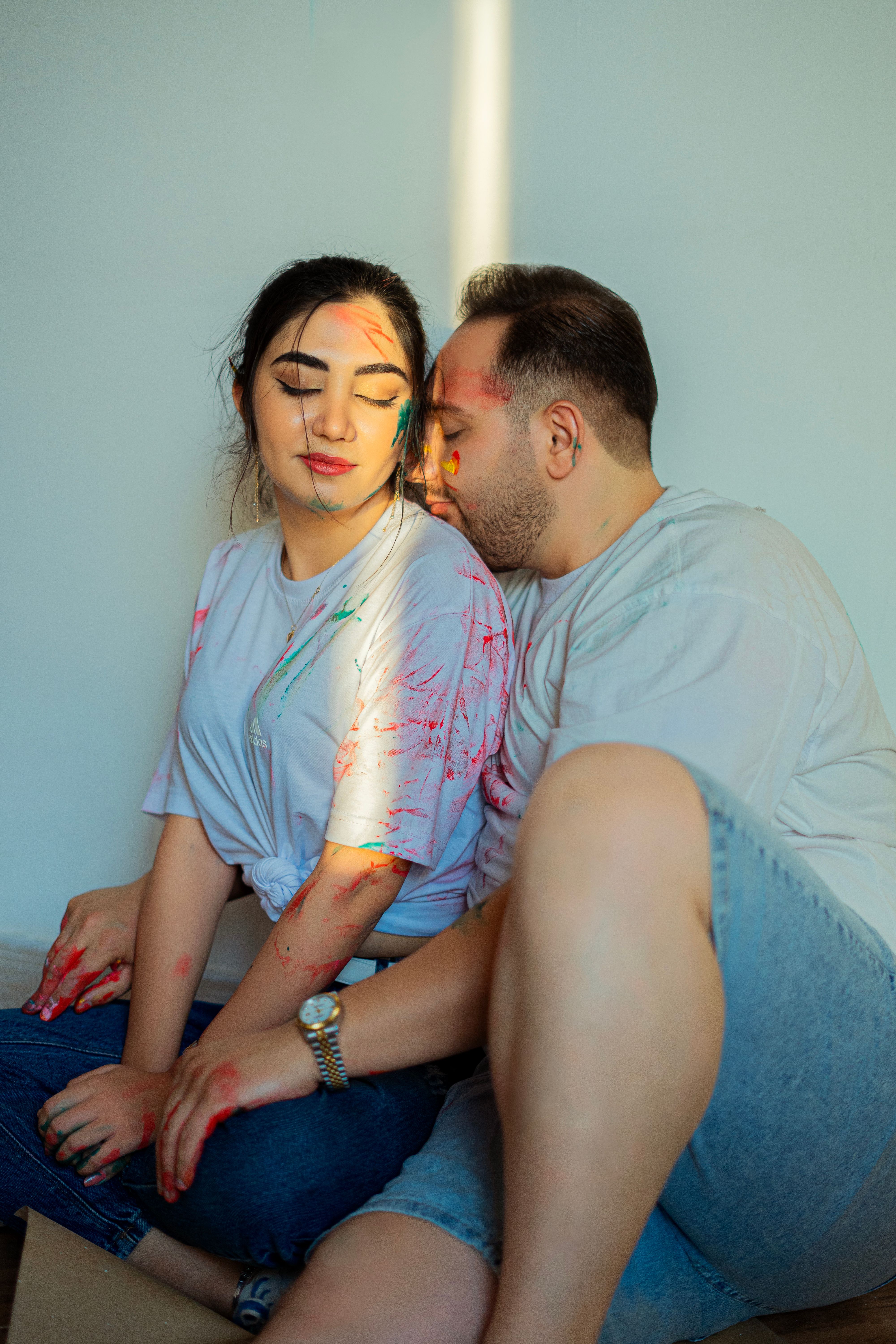 Couple Embracing with Colorful Paints in Sunlight · Free Stock Photo