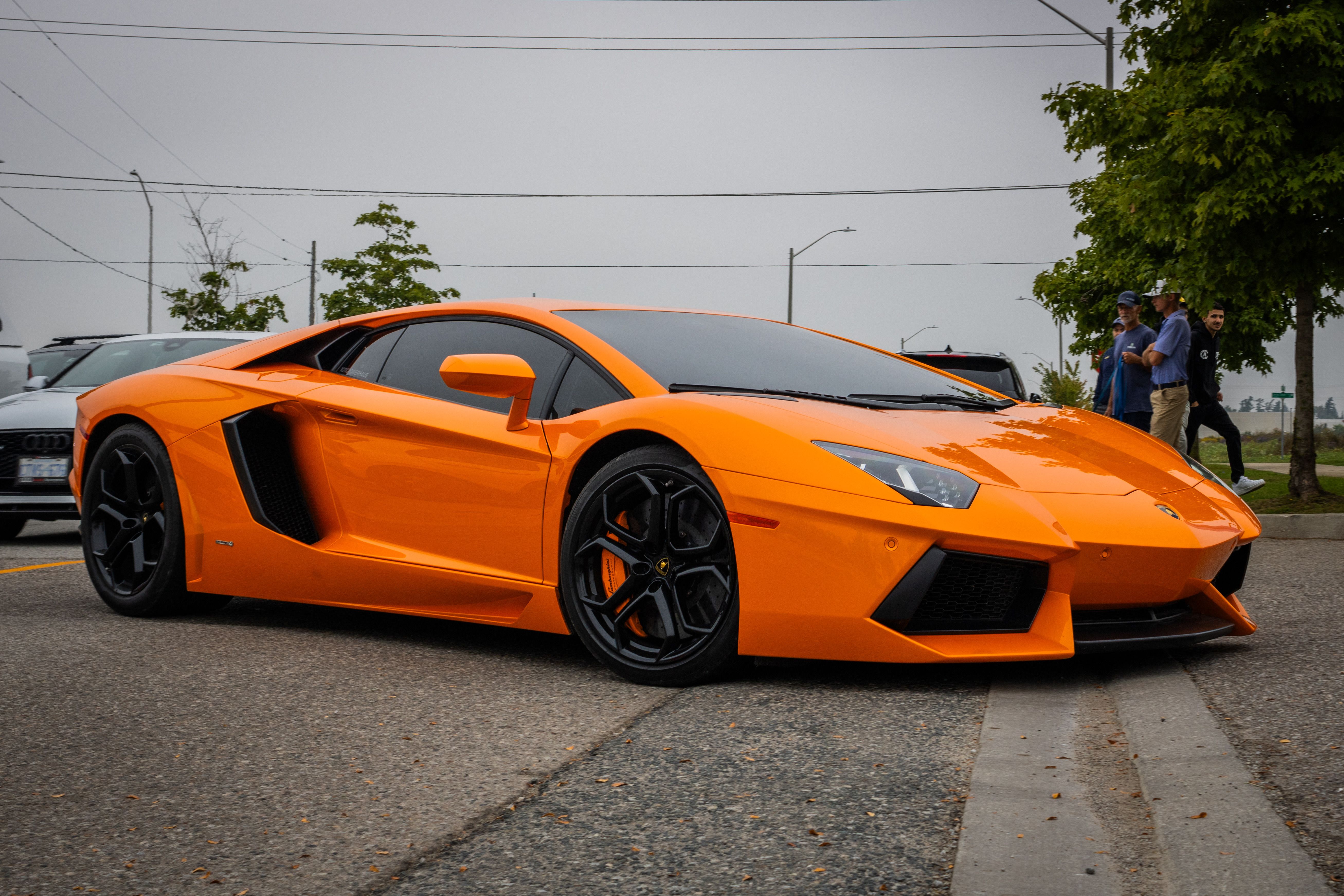 Vibrant Orange Sports Car Parked on Urban Street · Free Stock Photo