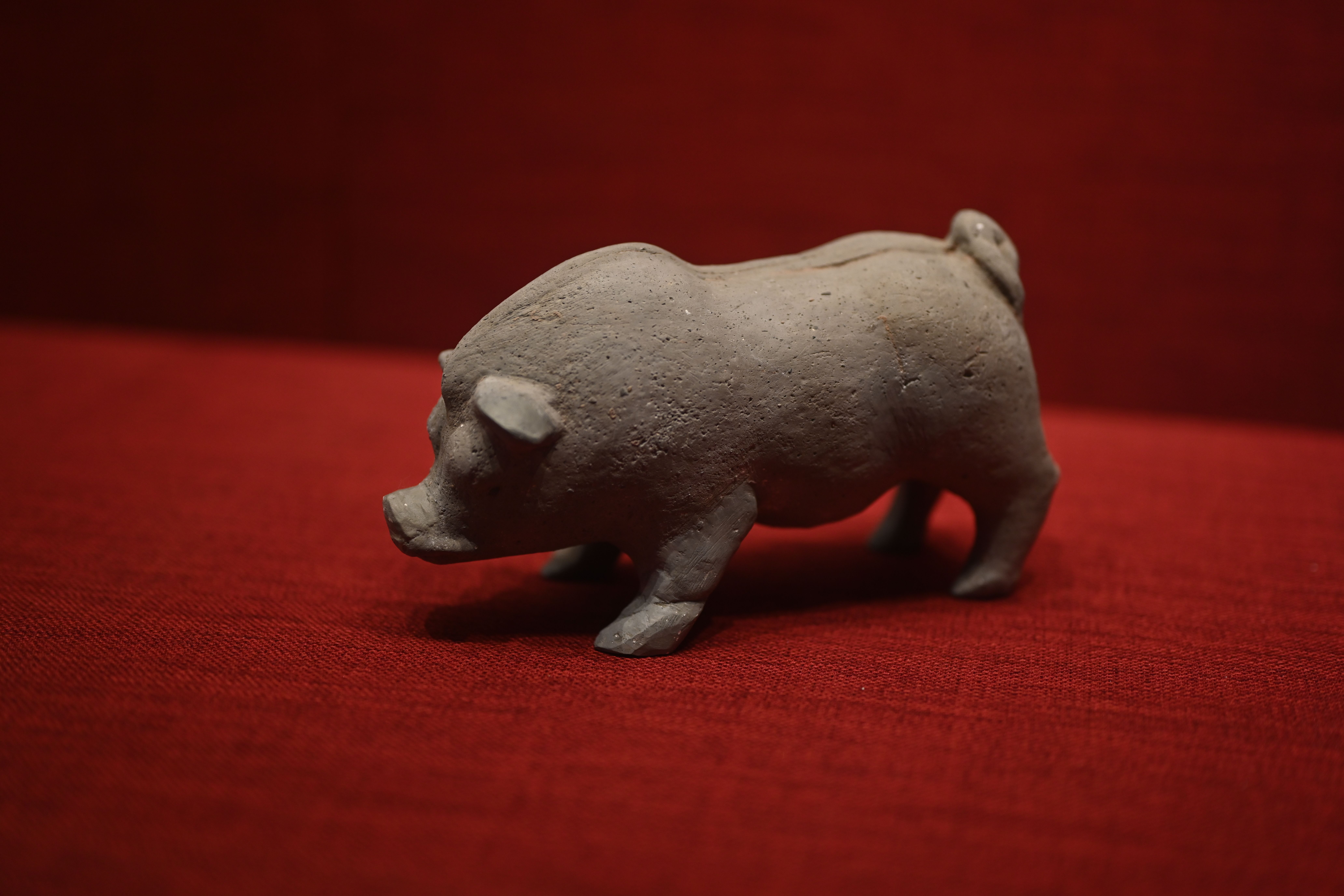 Rustic Clay Pig Figurine on Red Textile · Free Stock Photo