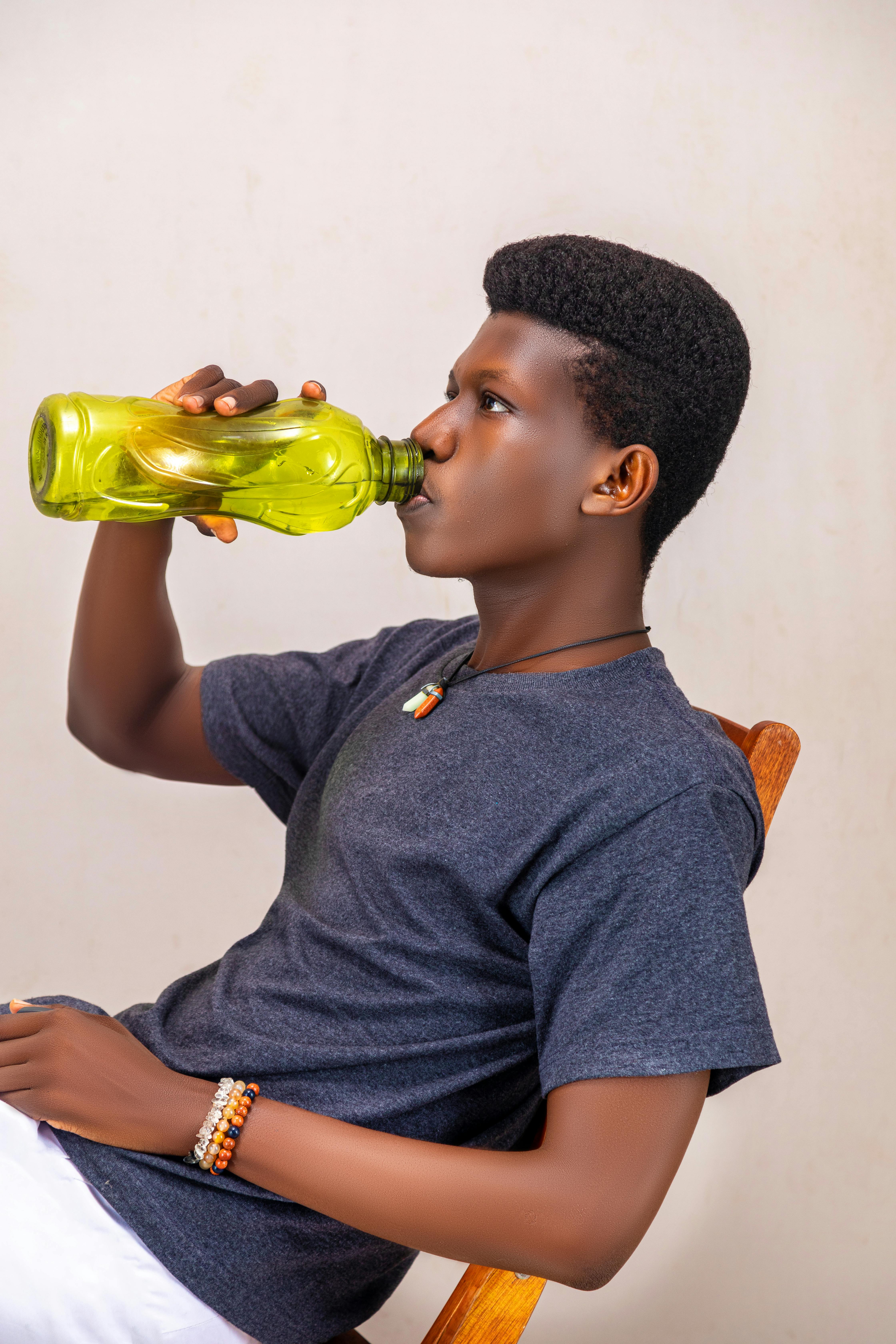 Young Man Staying Hydrated with Water Bottle · Free Stock Photo