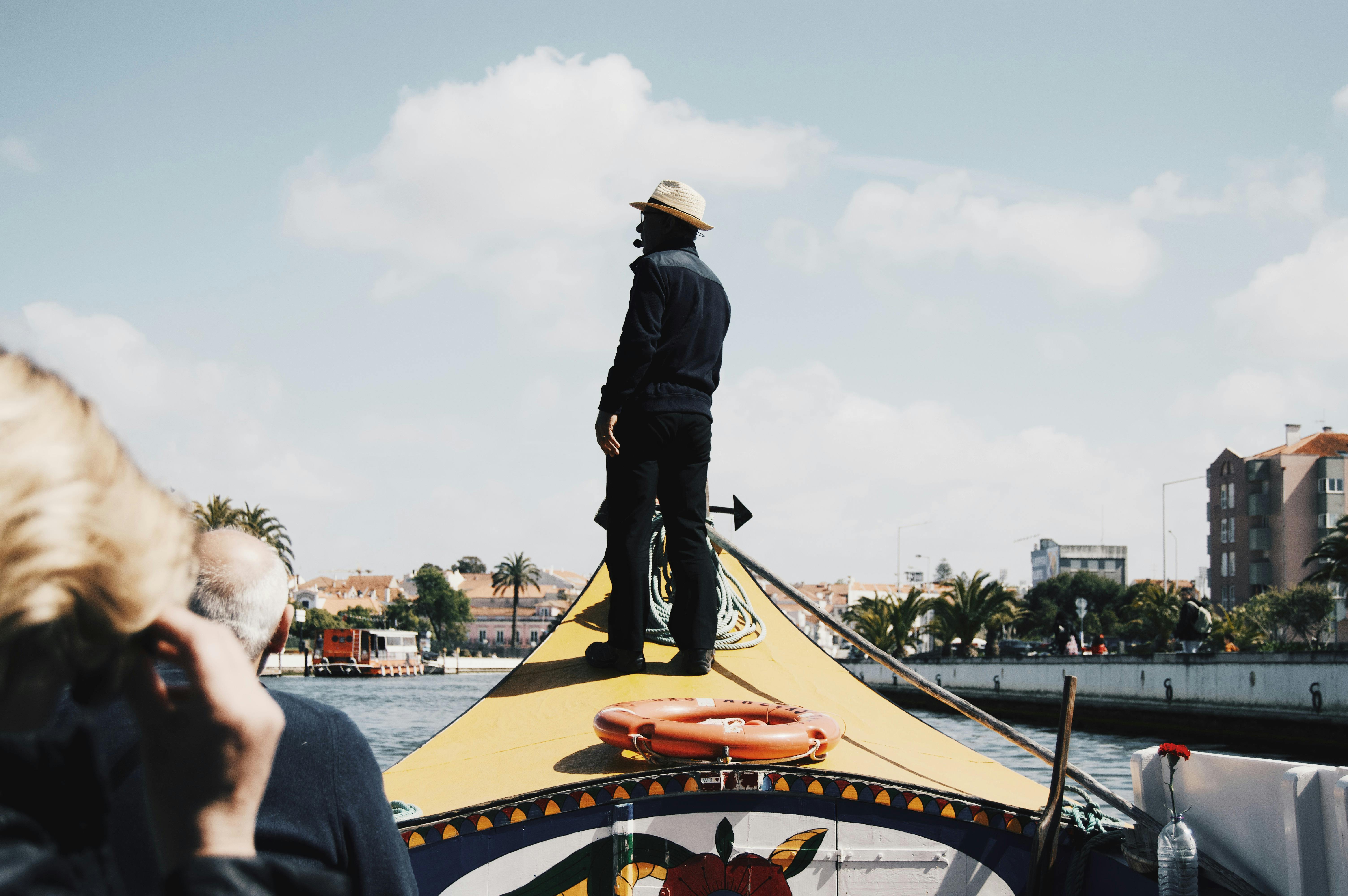 Black man standing on tourists boat front · Free Stock Photo