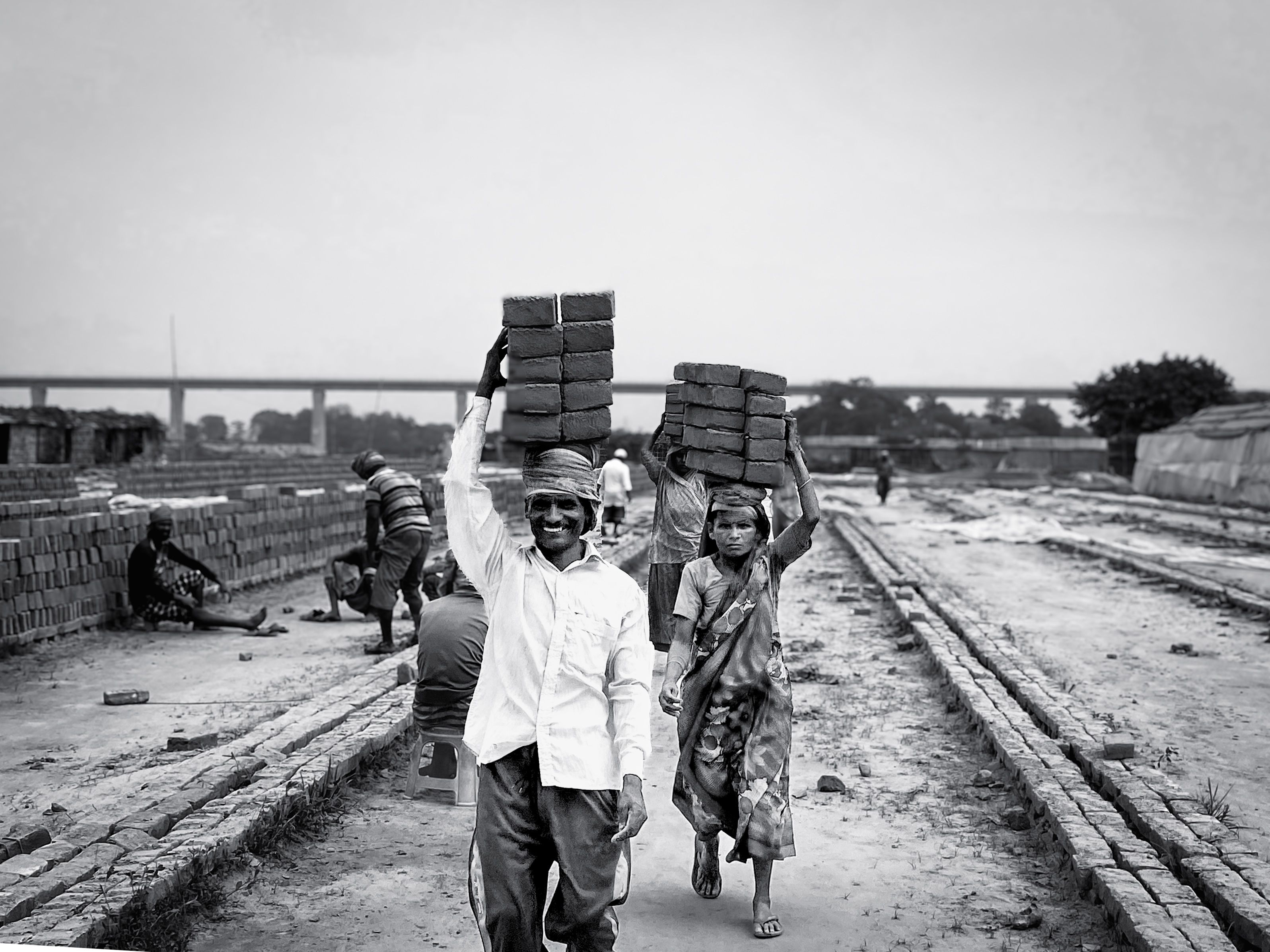 Workers Carrying Bricks at a Construction Site · Free Stock Photo