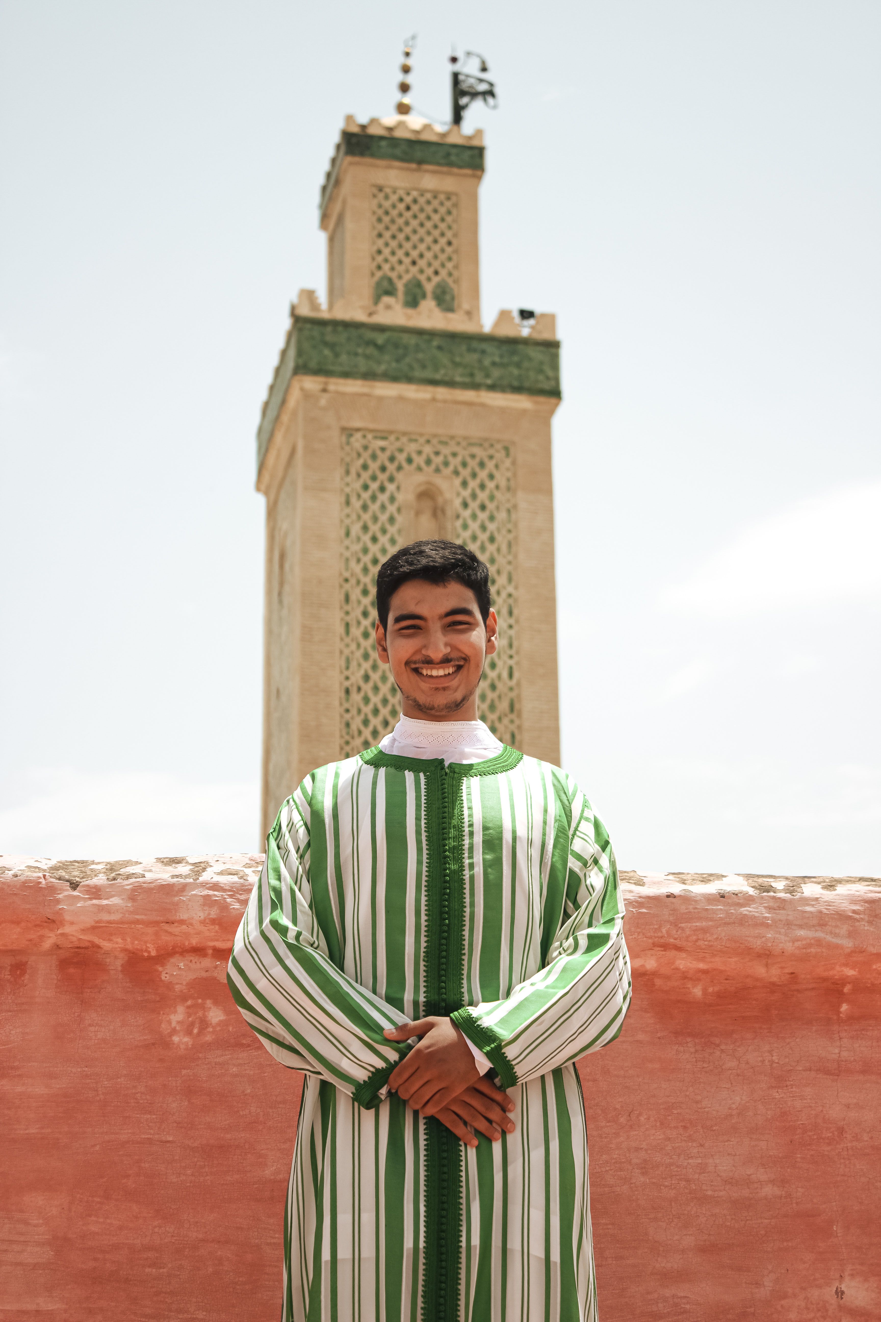 Smiling Man in Traditional Moroccan Clothing by Mosque · Free Stock Photo