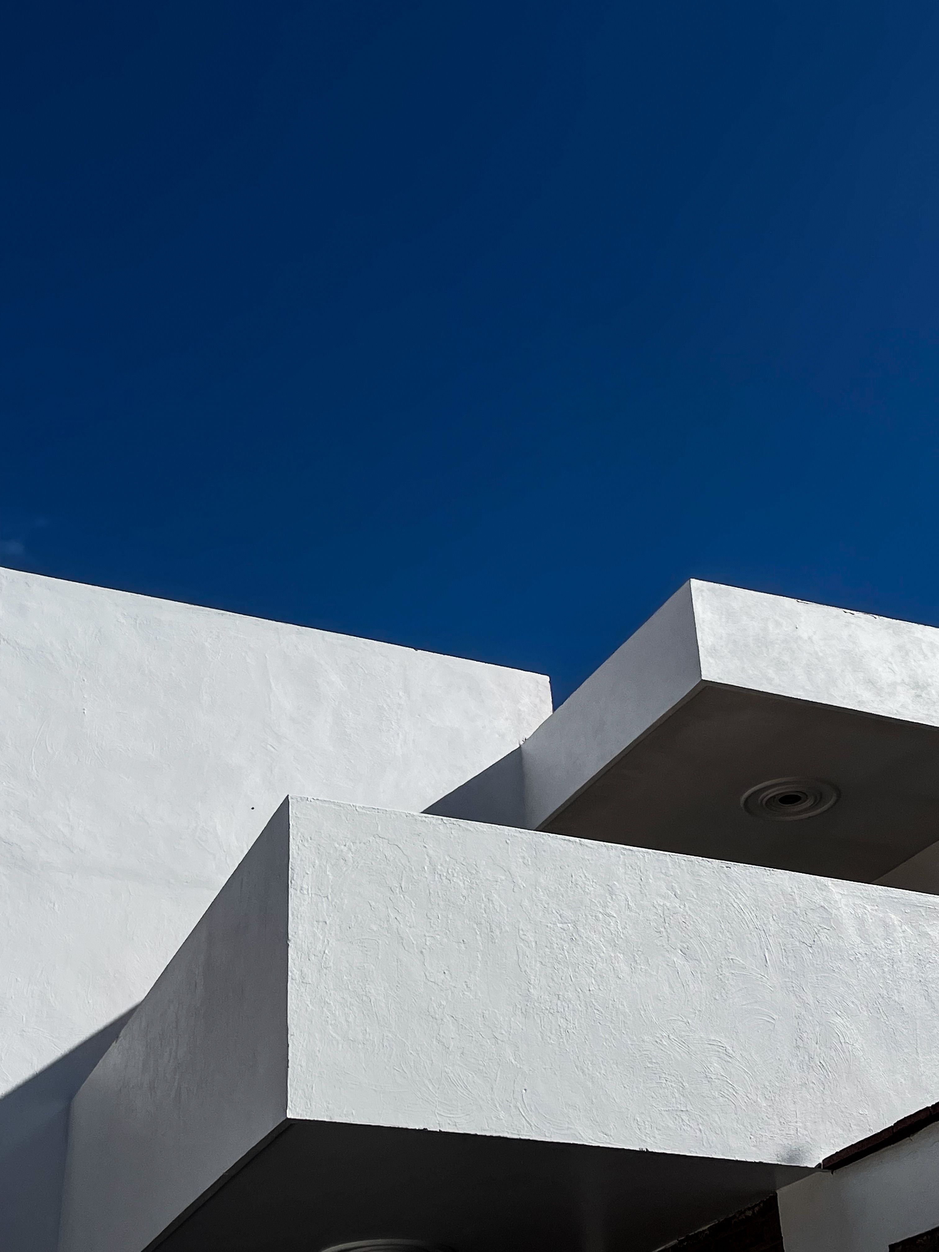 Modern Minimalist White Architecture Against Blue Sky · Free Stock Photo