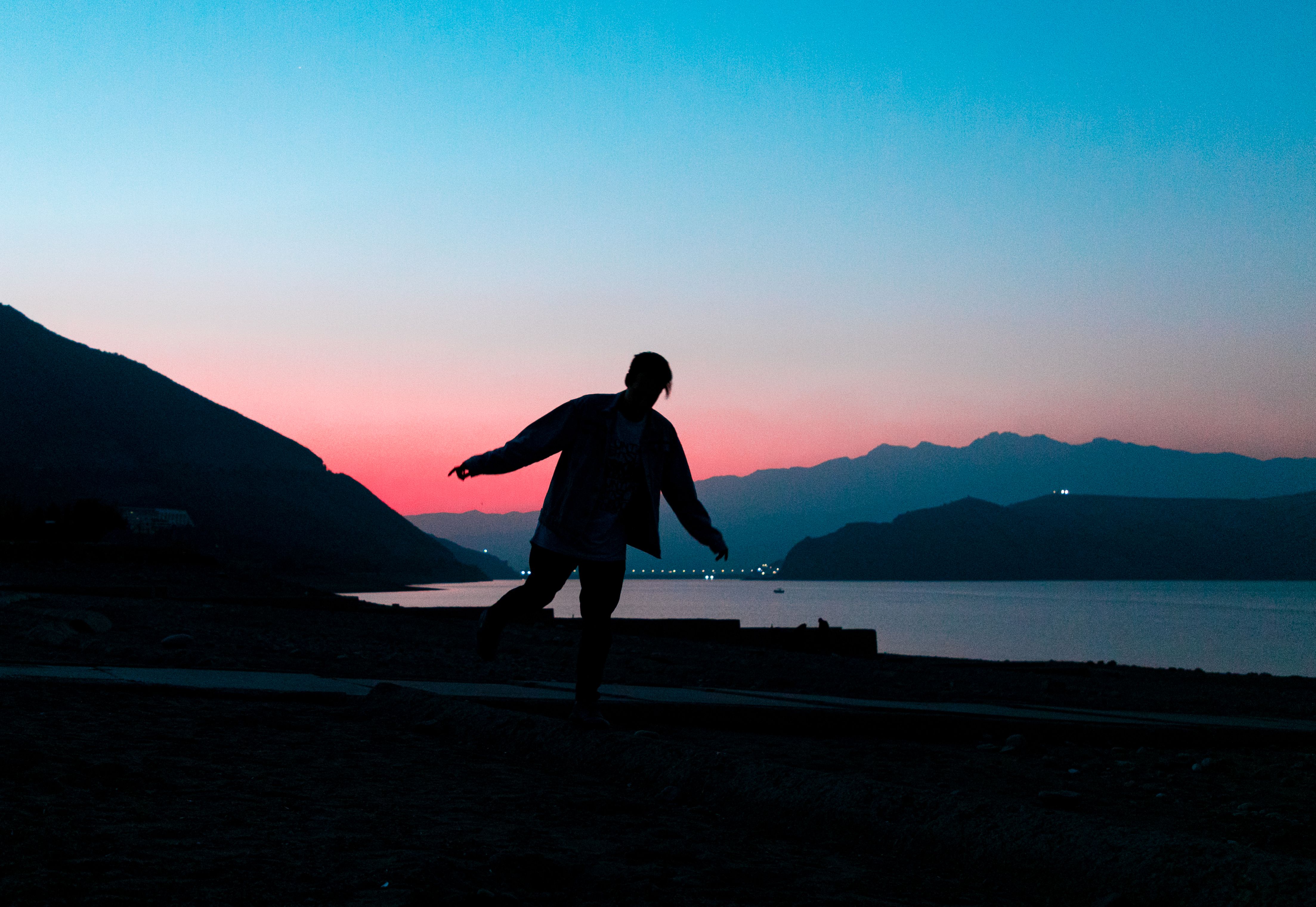 Silhouette of man standing on one leg on scenic riverside · Free Stock ...