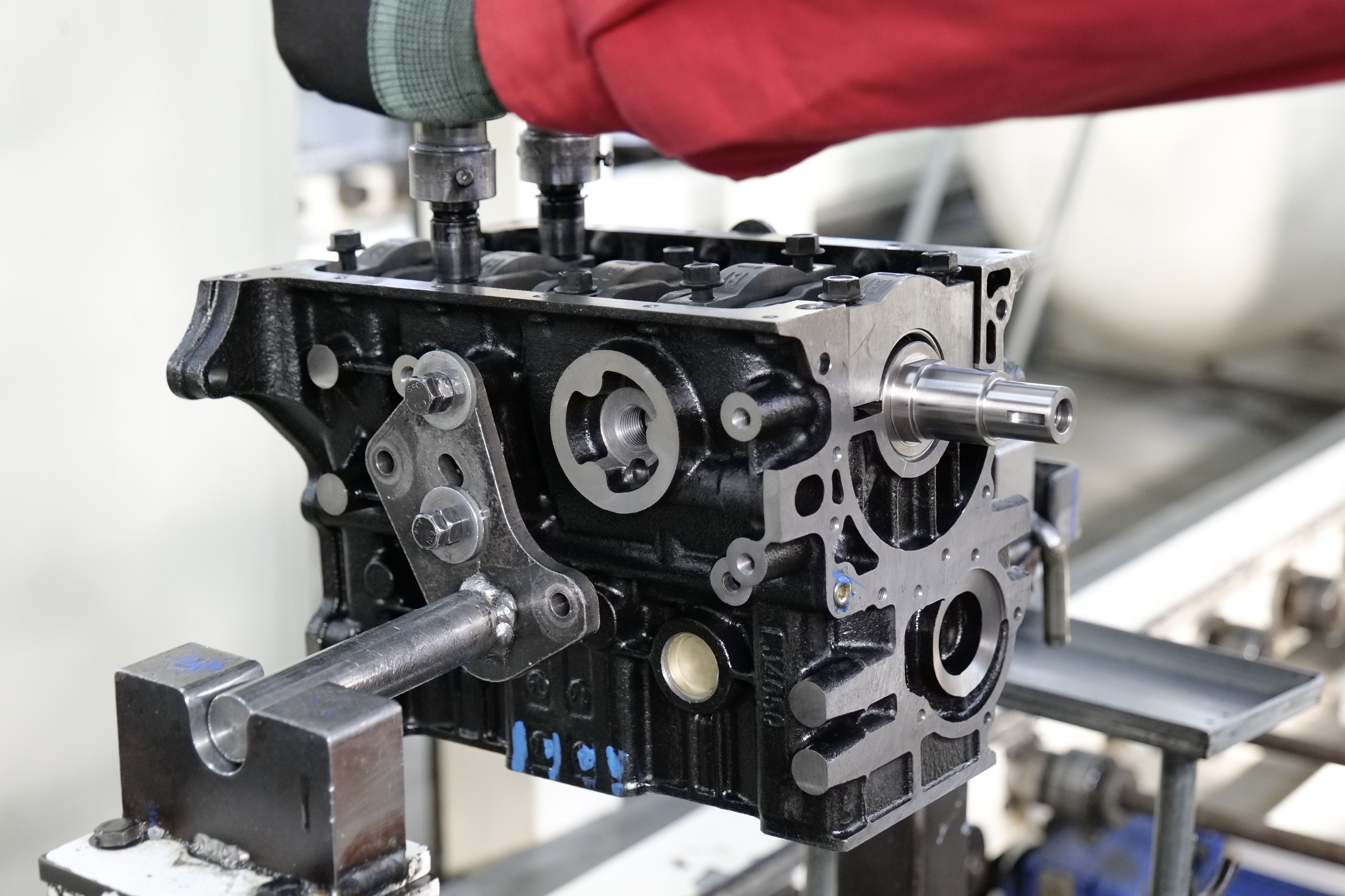 Mechanic Assembling Engine Block in Workshop · Free Stock Photo