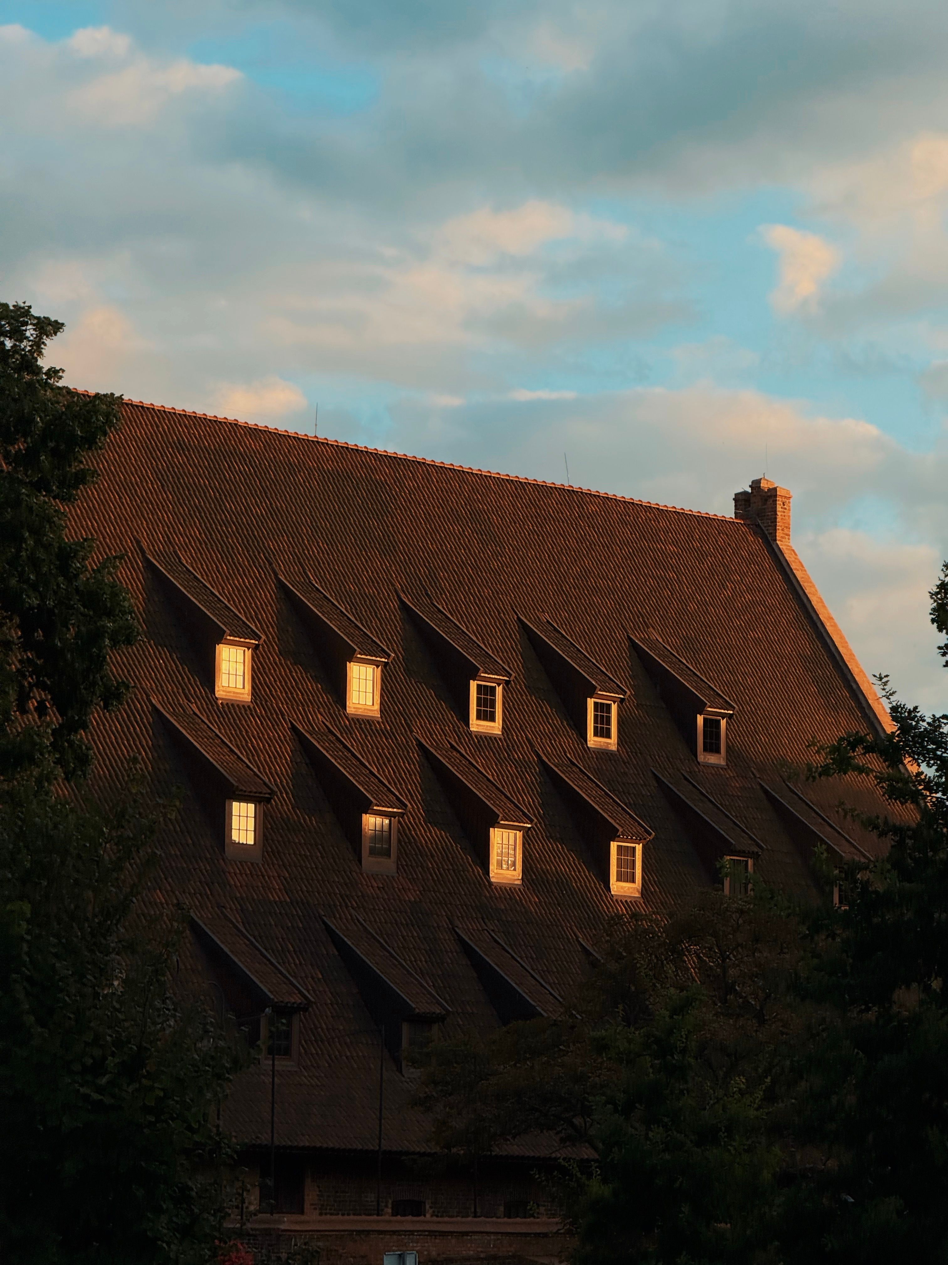 Sunlit Architectural Roof with Unique Windows · Free Stock Photo