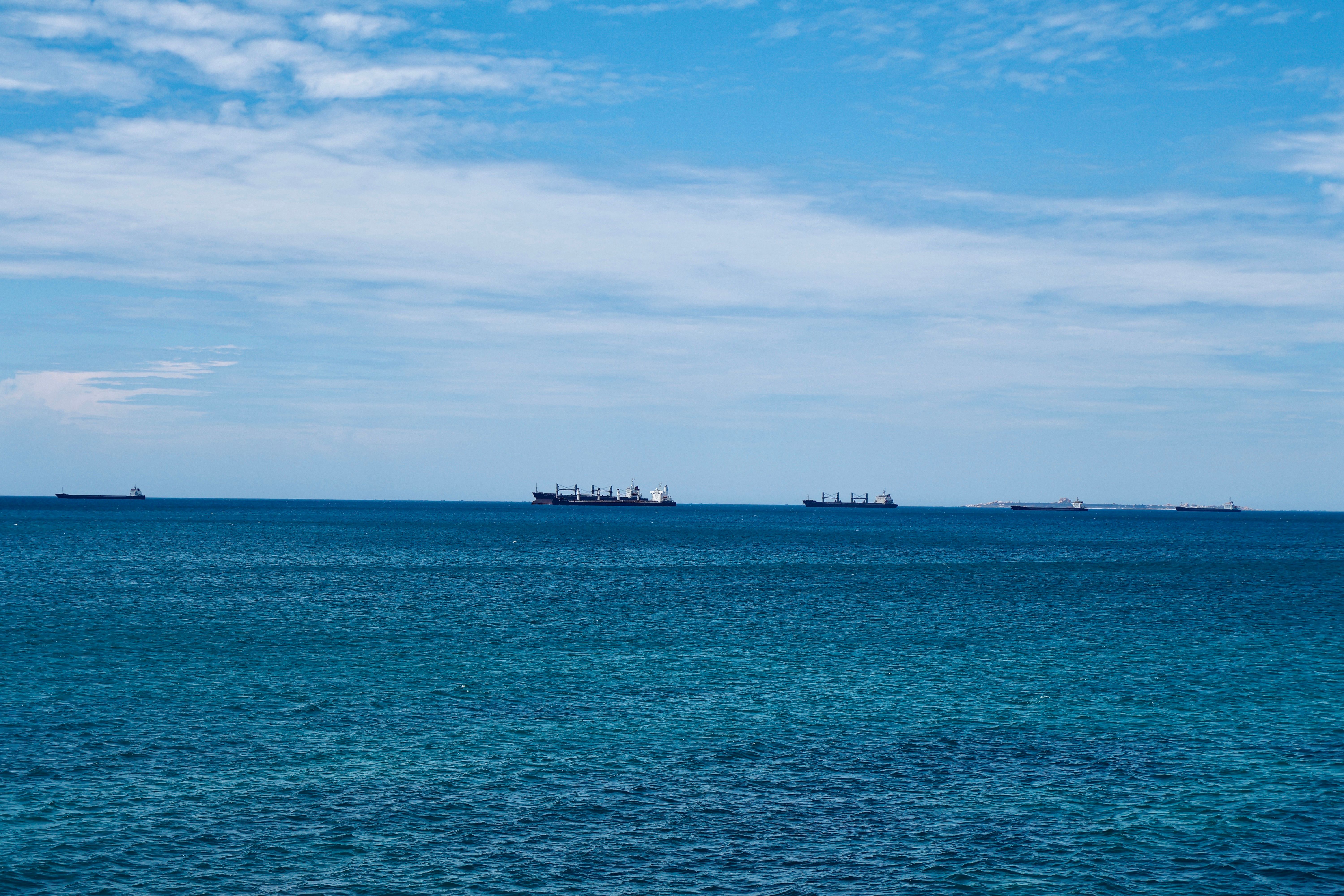 Cargo Ships on Open Sea Under Blue Sky · Free Stock Photo