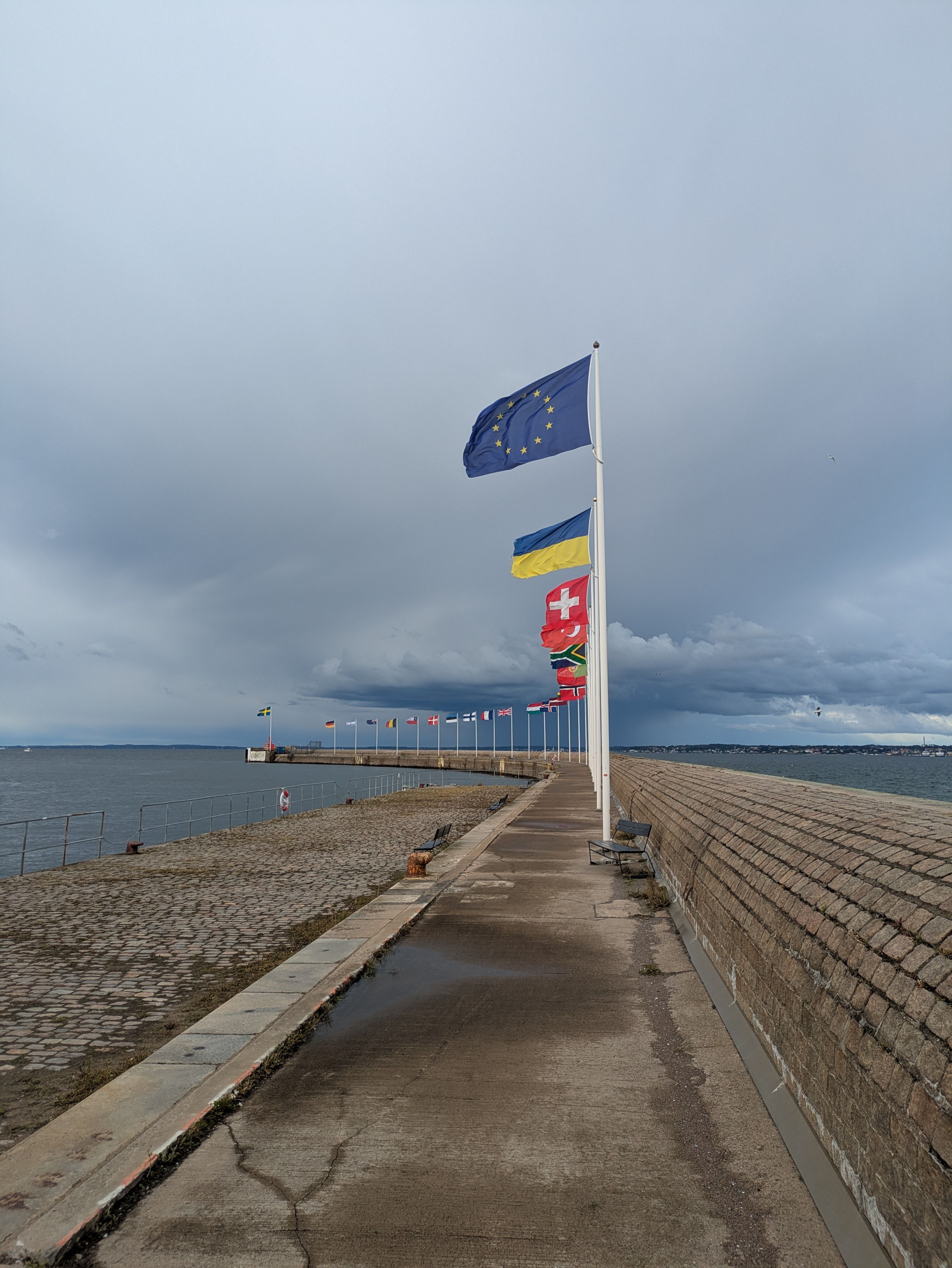 Flags on Pier against Moody Sky at Harbor · Free Stock Photo