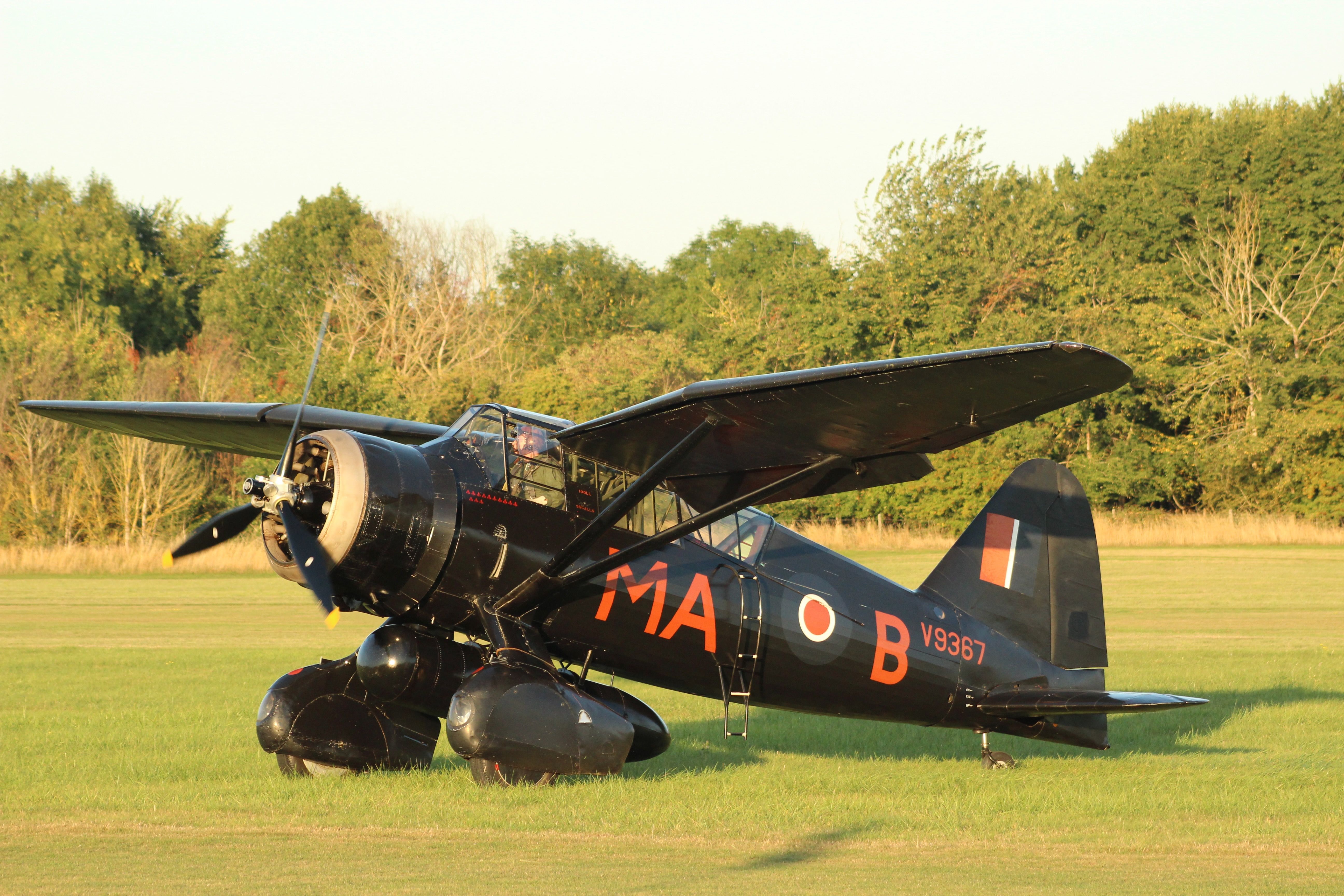 Vintage British Fighter Plane on Grass Field · Free Stock Photo