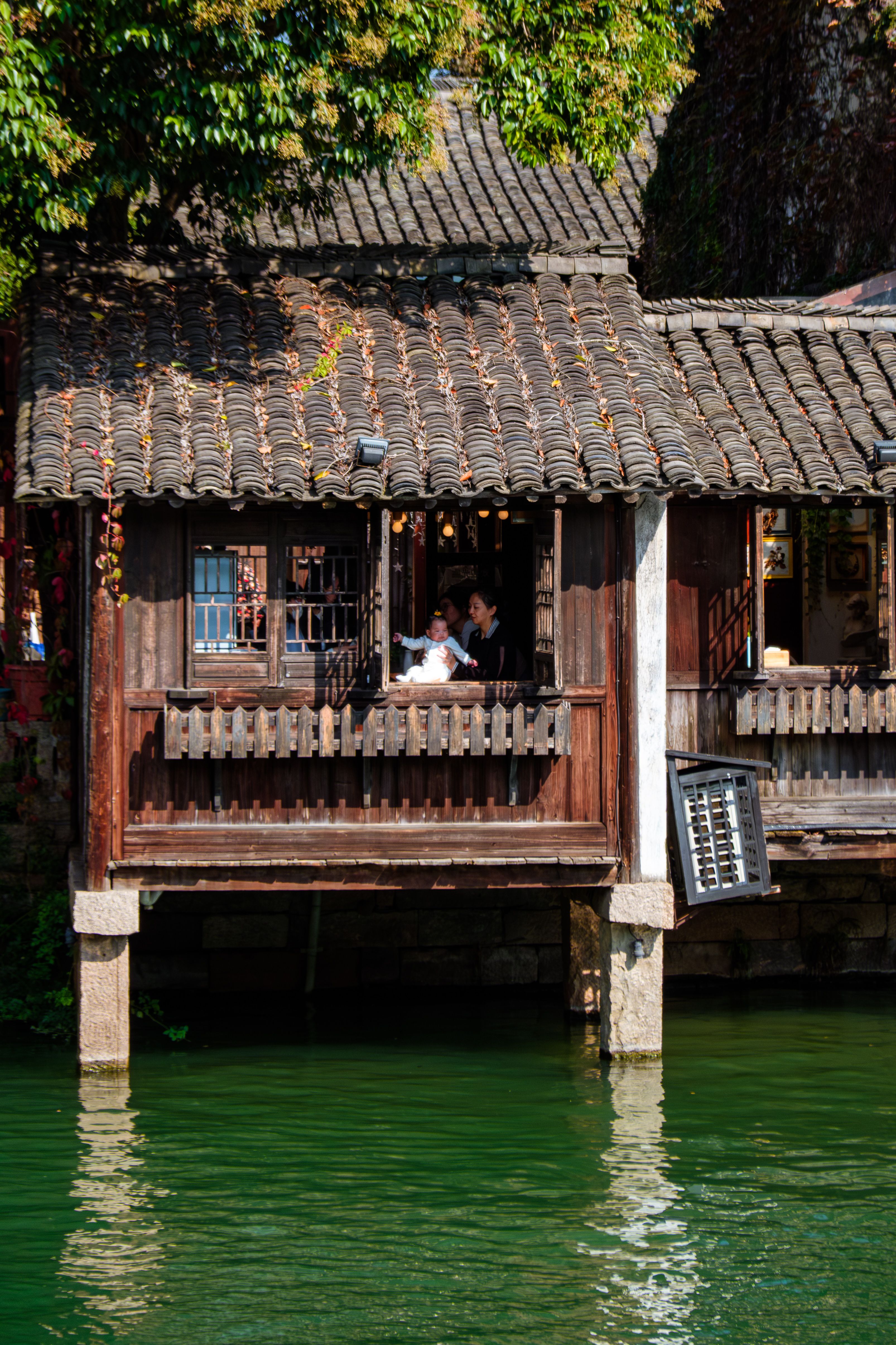 Traditional Asian riverside house with people · Free Stock Photo
