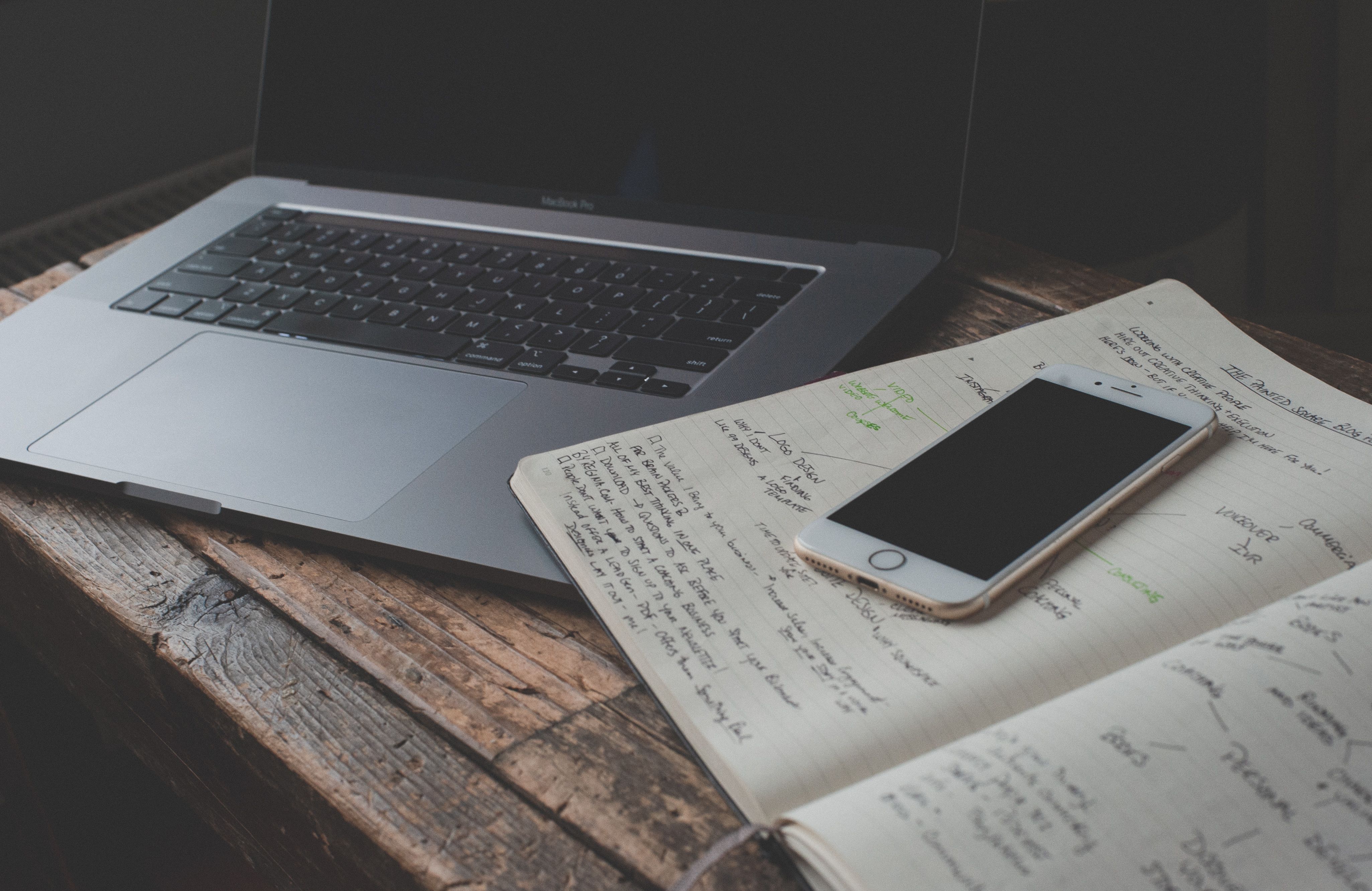 Iphone on Notebook Beside Laptop · Free Stock Photo