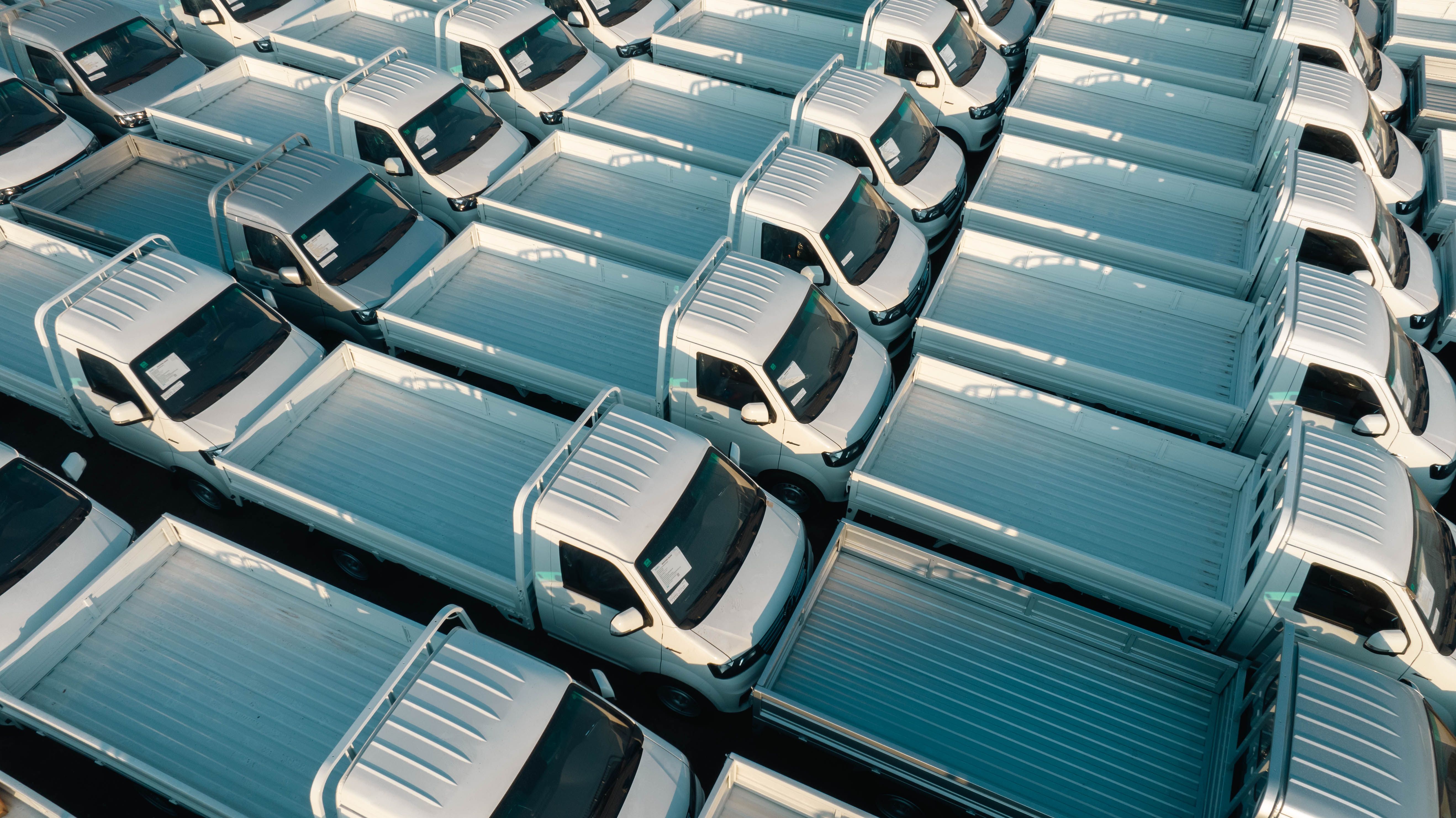 Aerial View of Multiple White Pickup Trucks Parked · Free Stock Photo