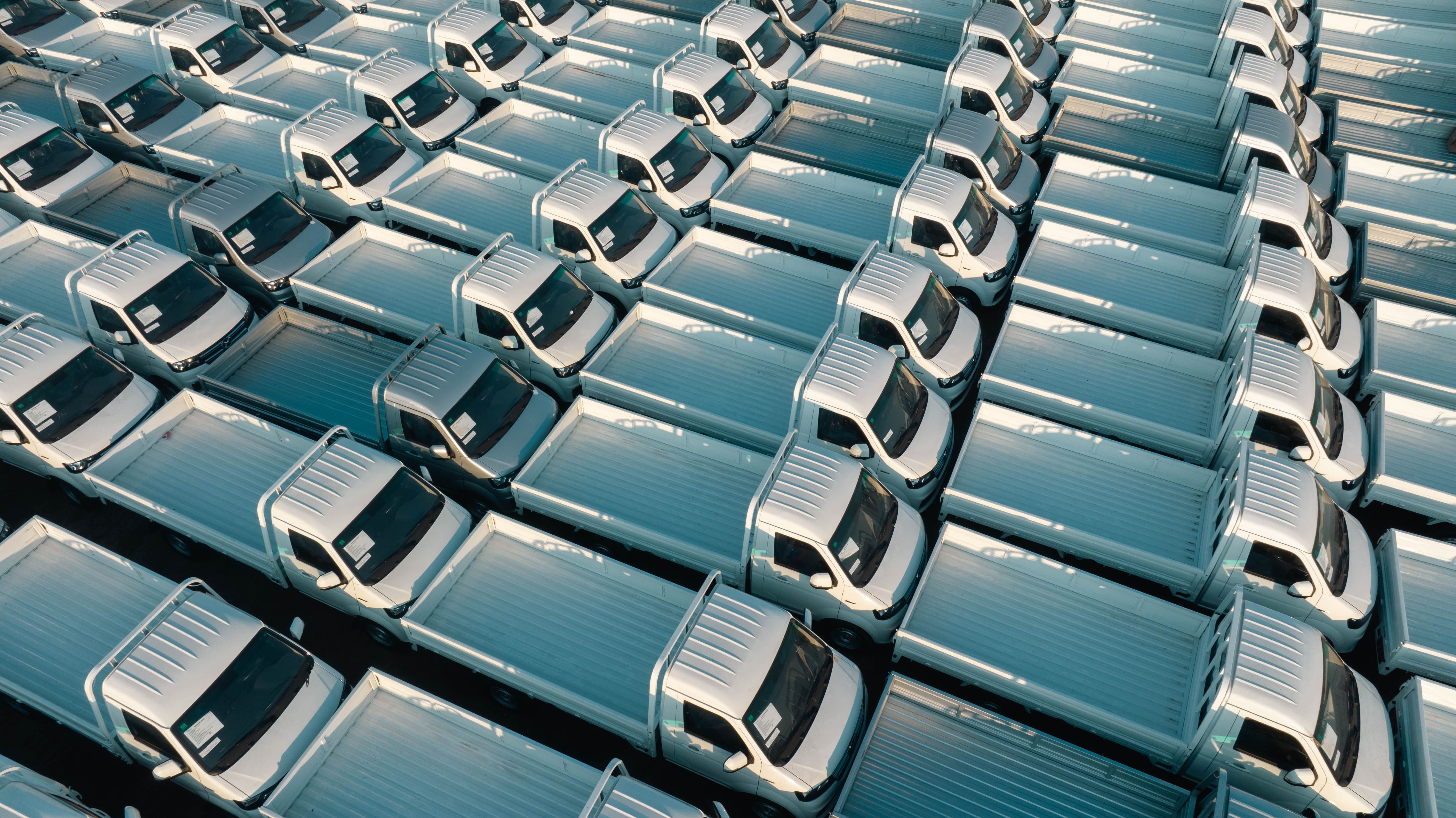 Aerial View of Multiple White Trucks in Grid Formation · Free Stock Photo