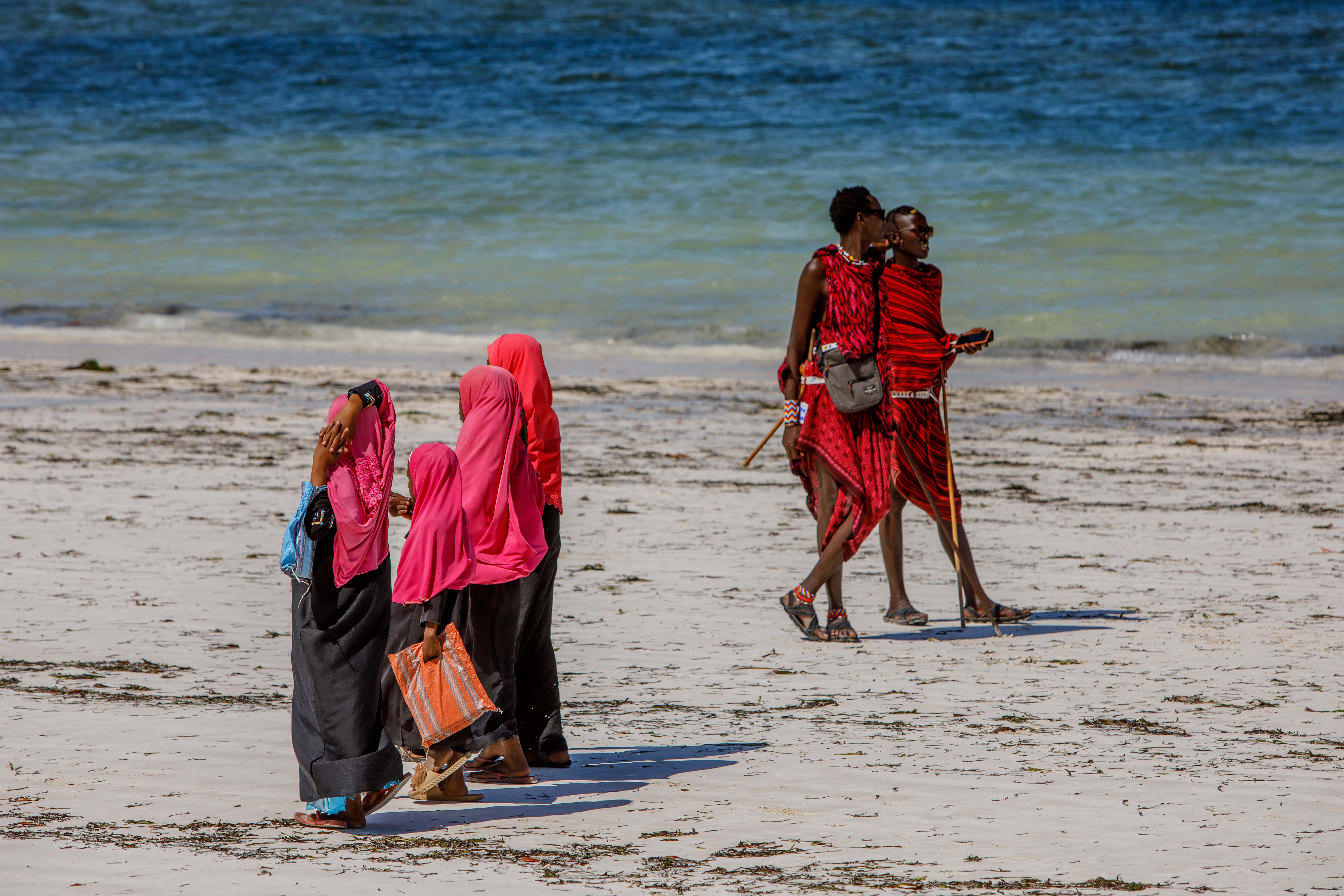 Beach Walk in Vibrant Traditional Attire · Free Stock Photo