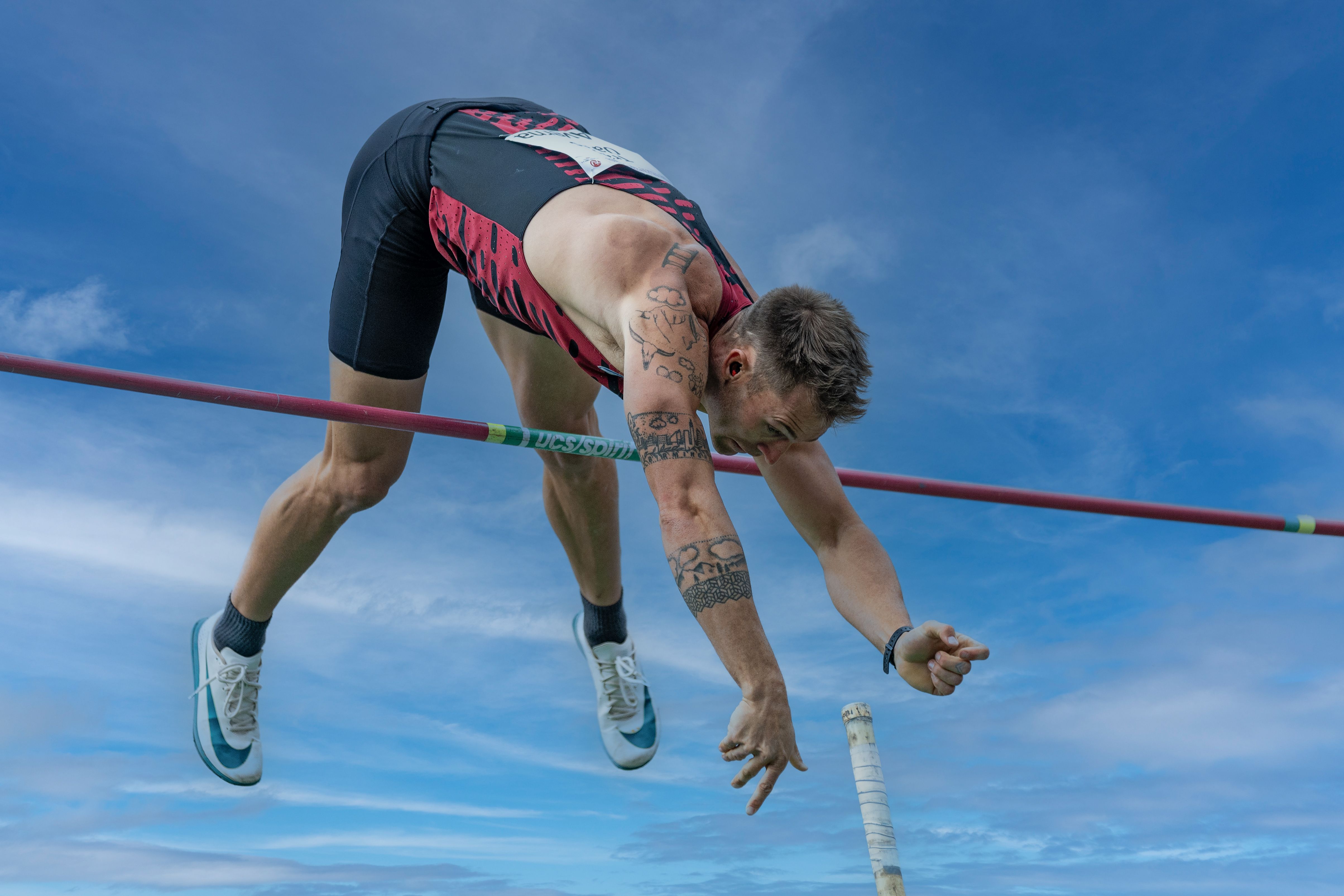 Professional Pole Vaulter Mid-Action Leap Outdoors · Free Stock Photo