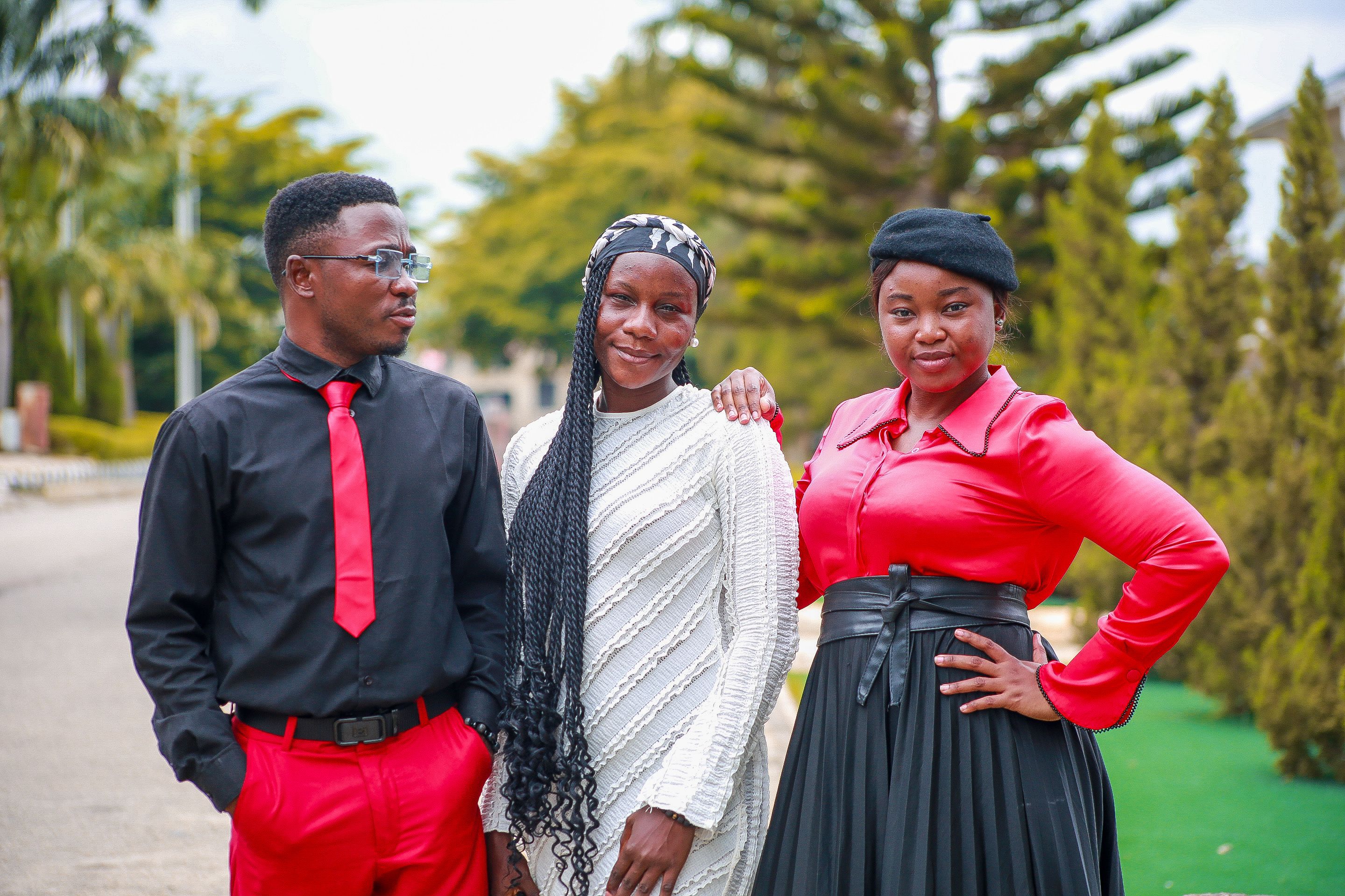 Three people standing together in a park · Free Stock Photo