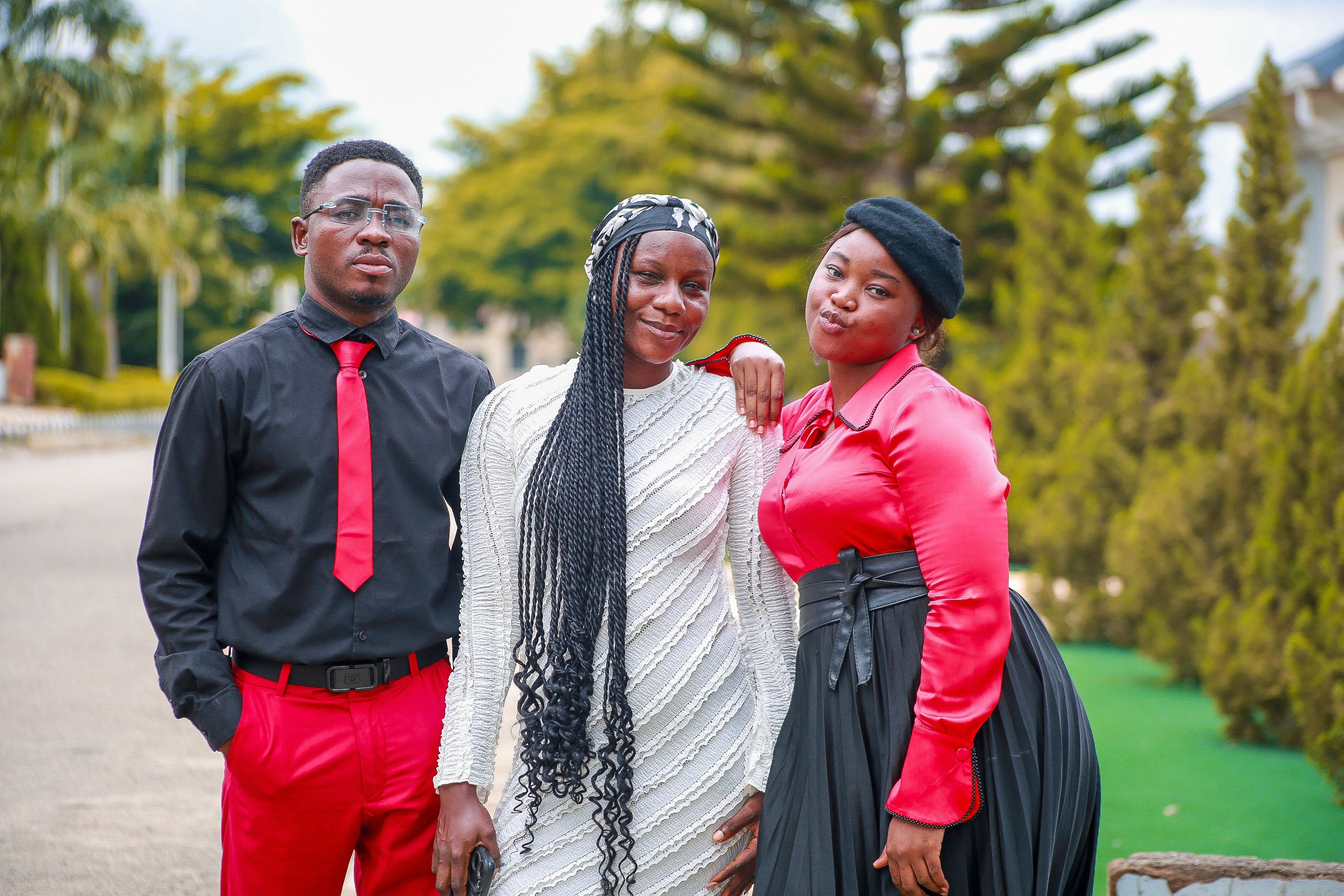 Three people standing together in a park · Free Stock Photo