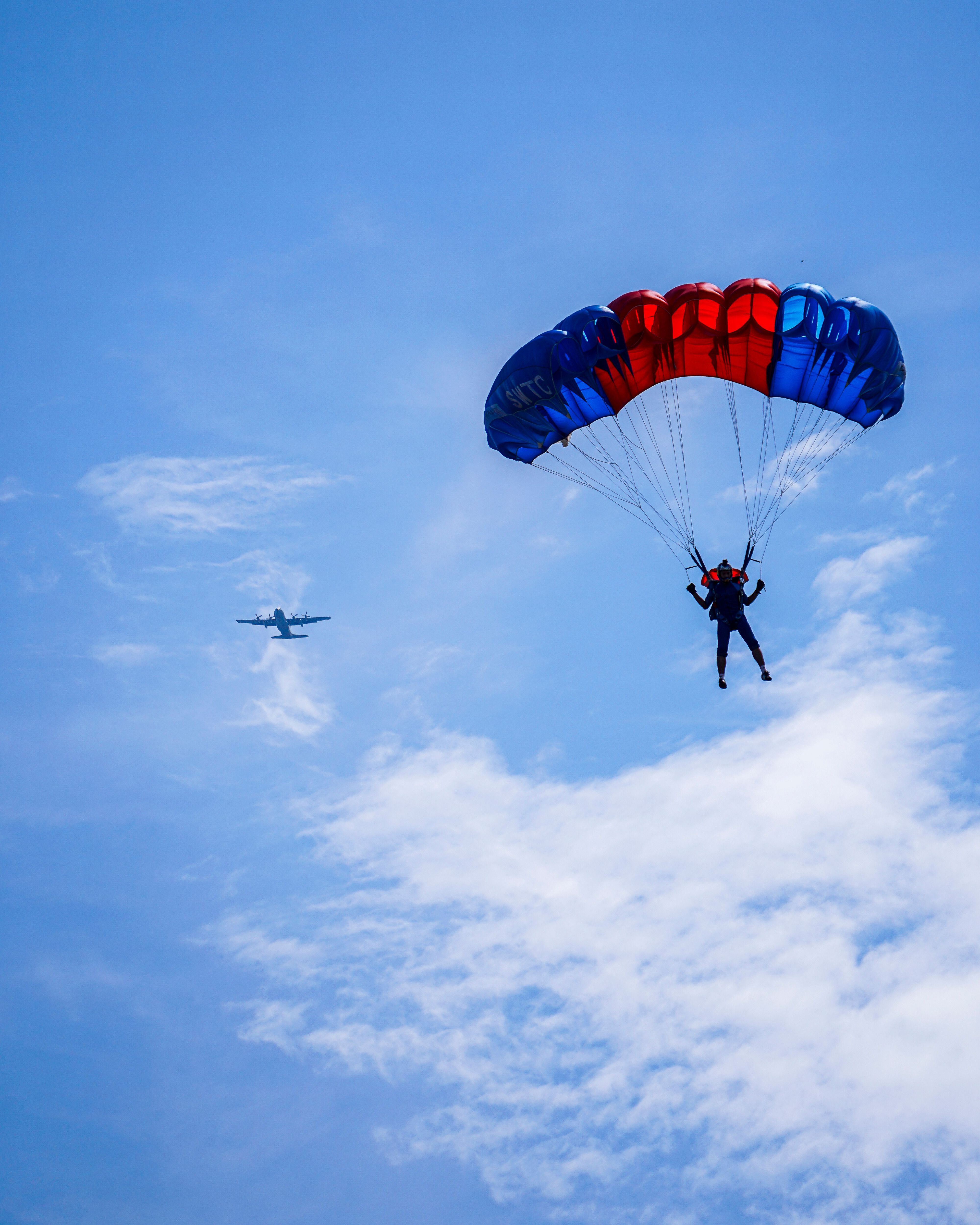 Paratrooper Landing in Open Field During Training · Free Stock Photo