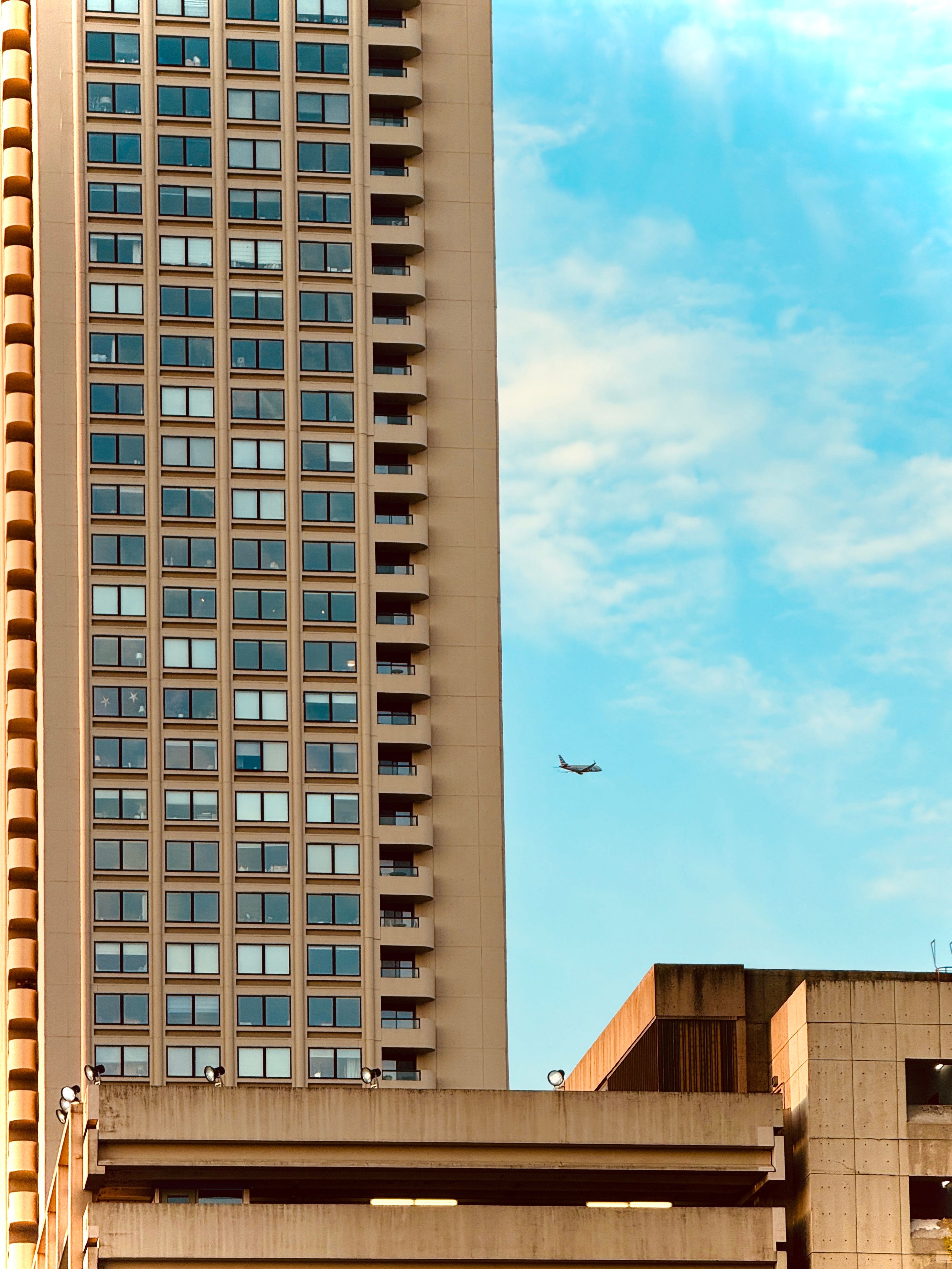 Urban Skyline with Airplane in Flight · Free Stock Photo