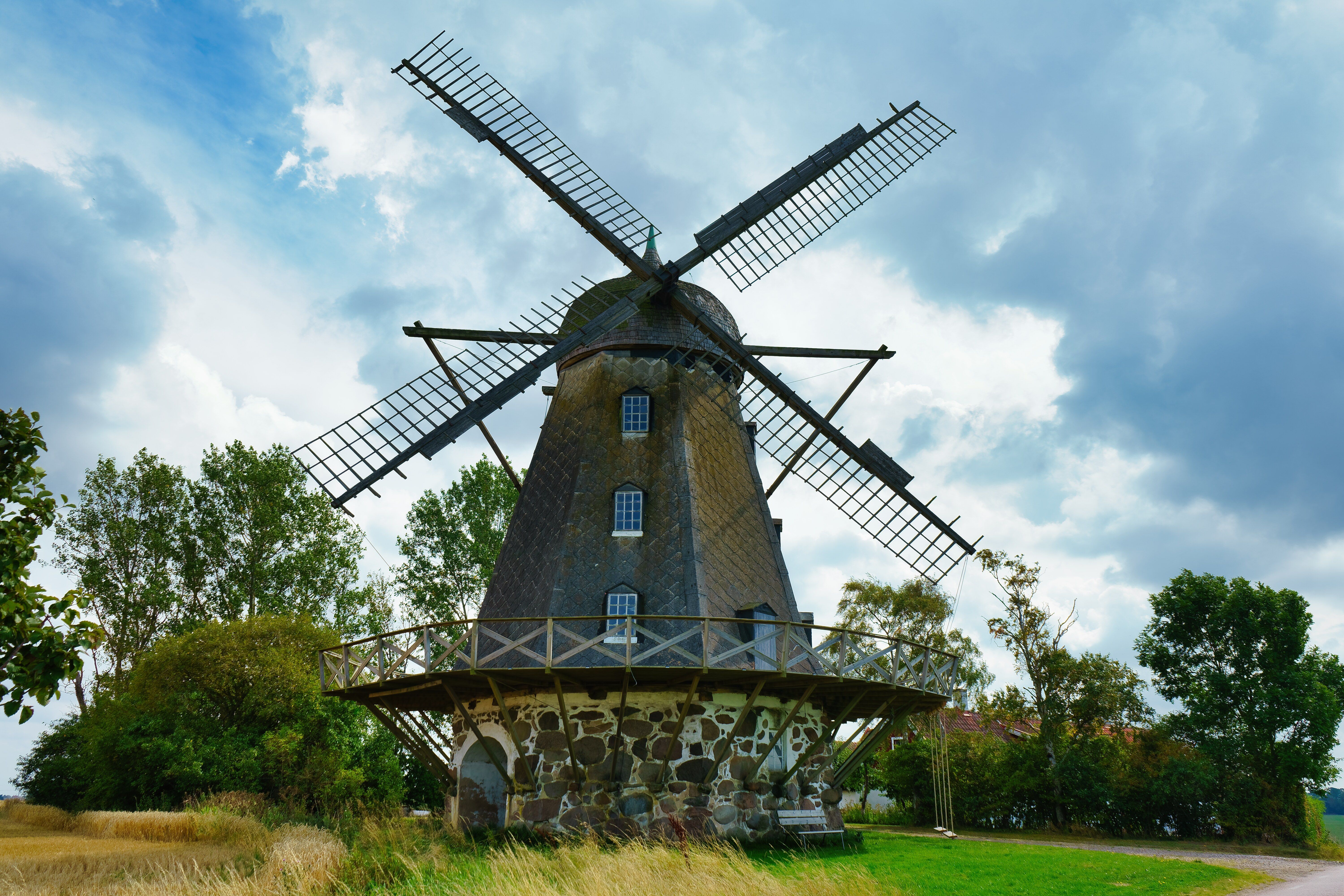 Brown and Gray Windmill Beside Green Tree Under Blue Cloudy Sky during ...